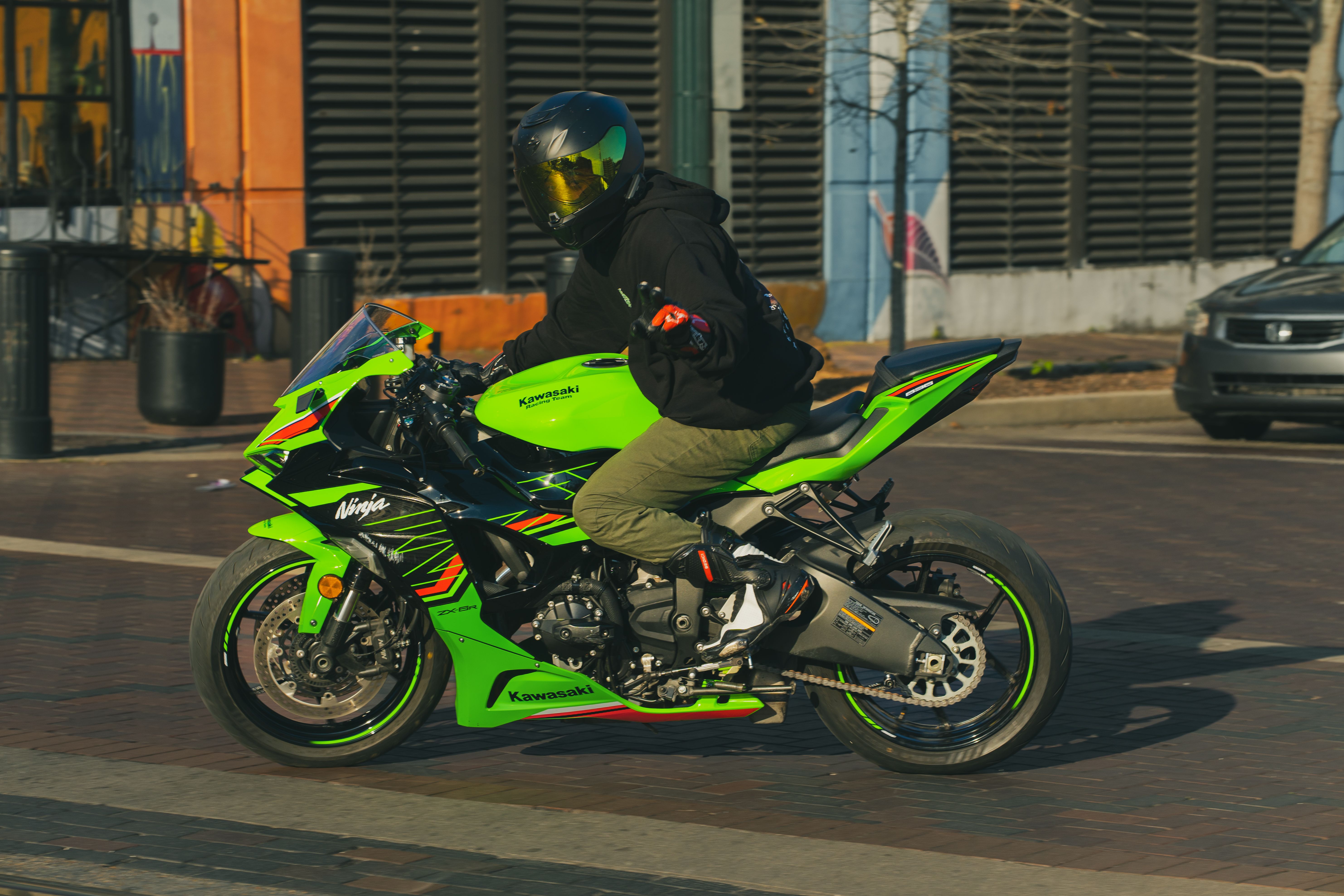 Un Motard Conduit Une Kawasaki Verte Dans La Ville De Houston · Photo ...