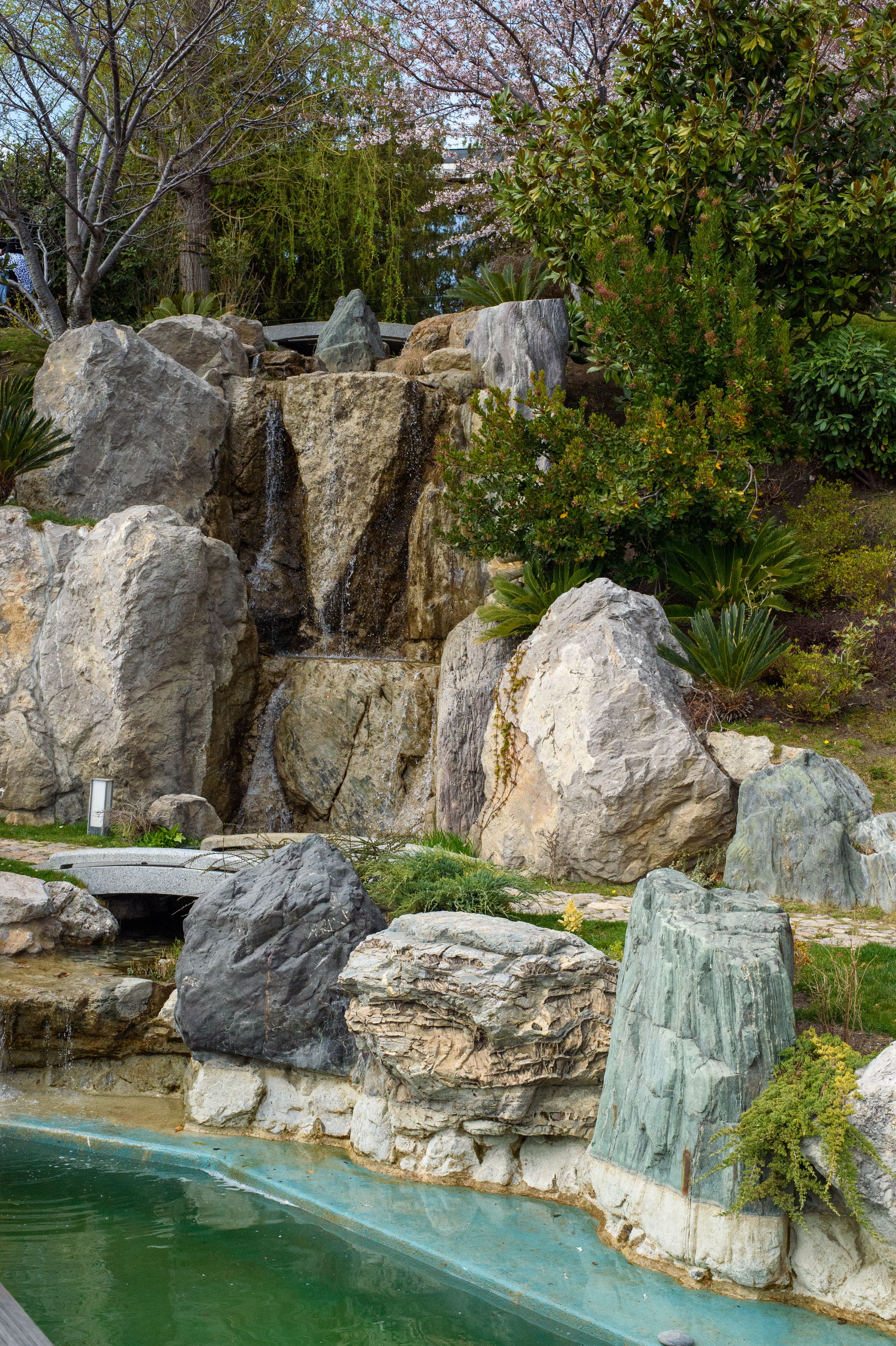 Serene Natural Rock Waterfall in Lush Garden · Free Stock Photo