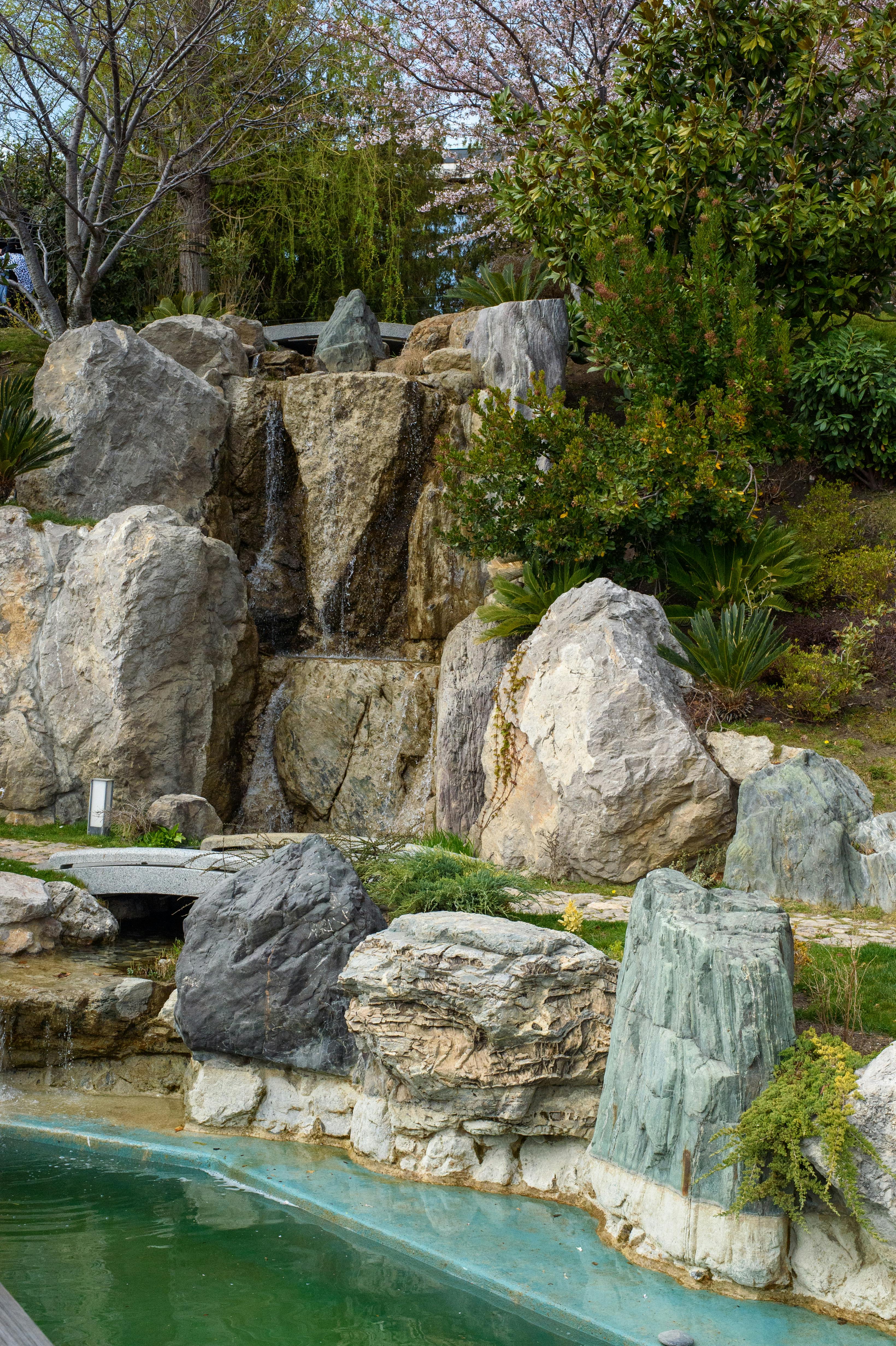 Serene Natural Rock Waterfall in Lush Garden · Free Stock Photo