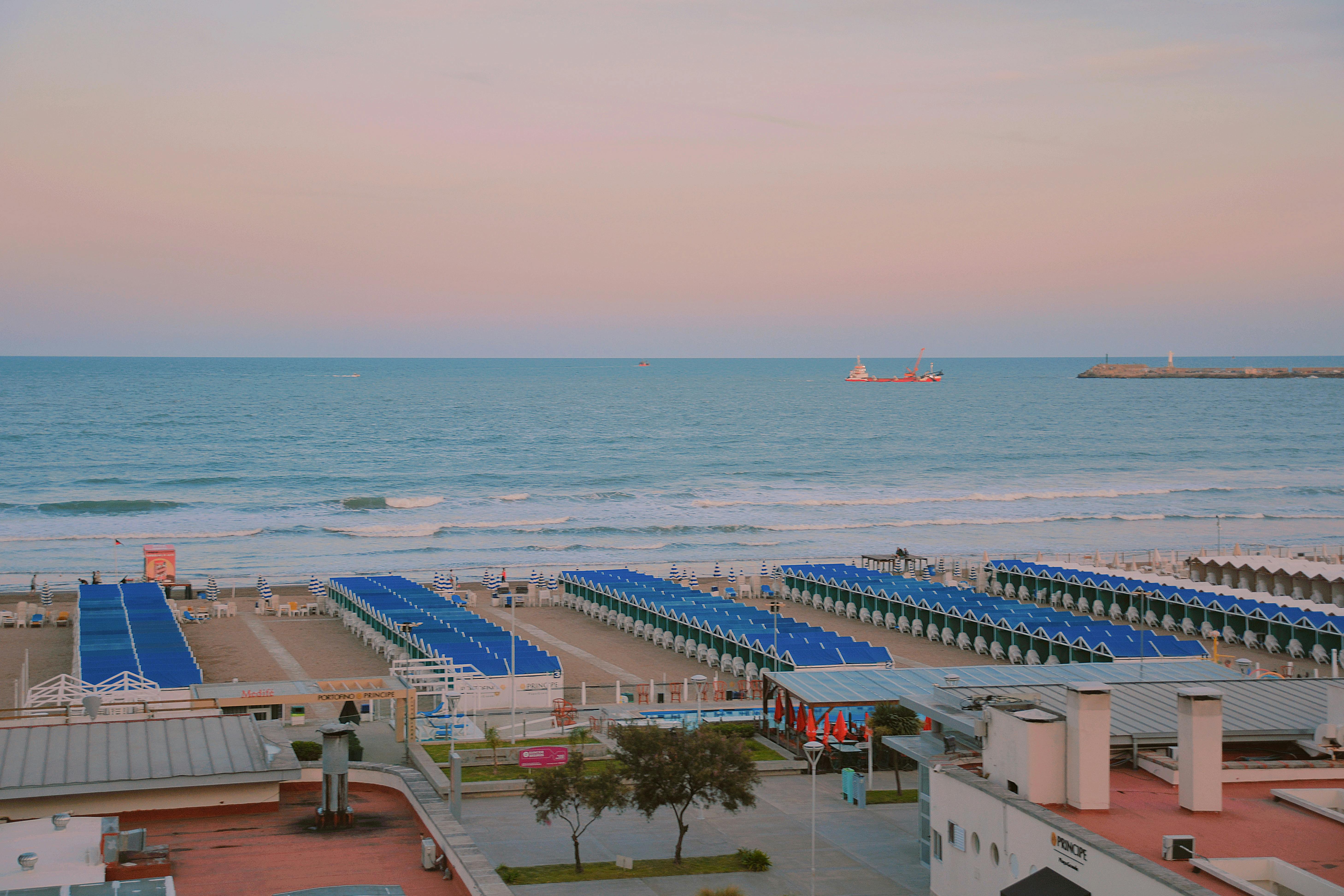 Serene Beachfront View with Colorful Sunshades · Free Stock Photo