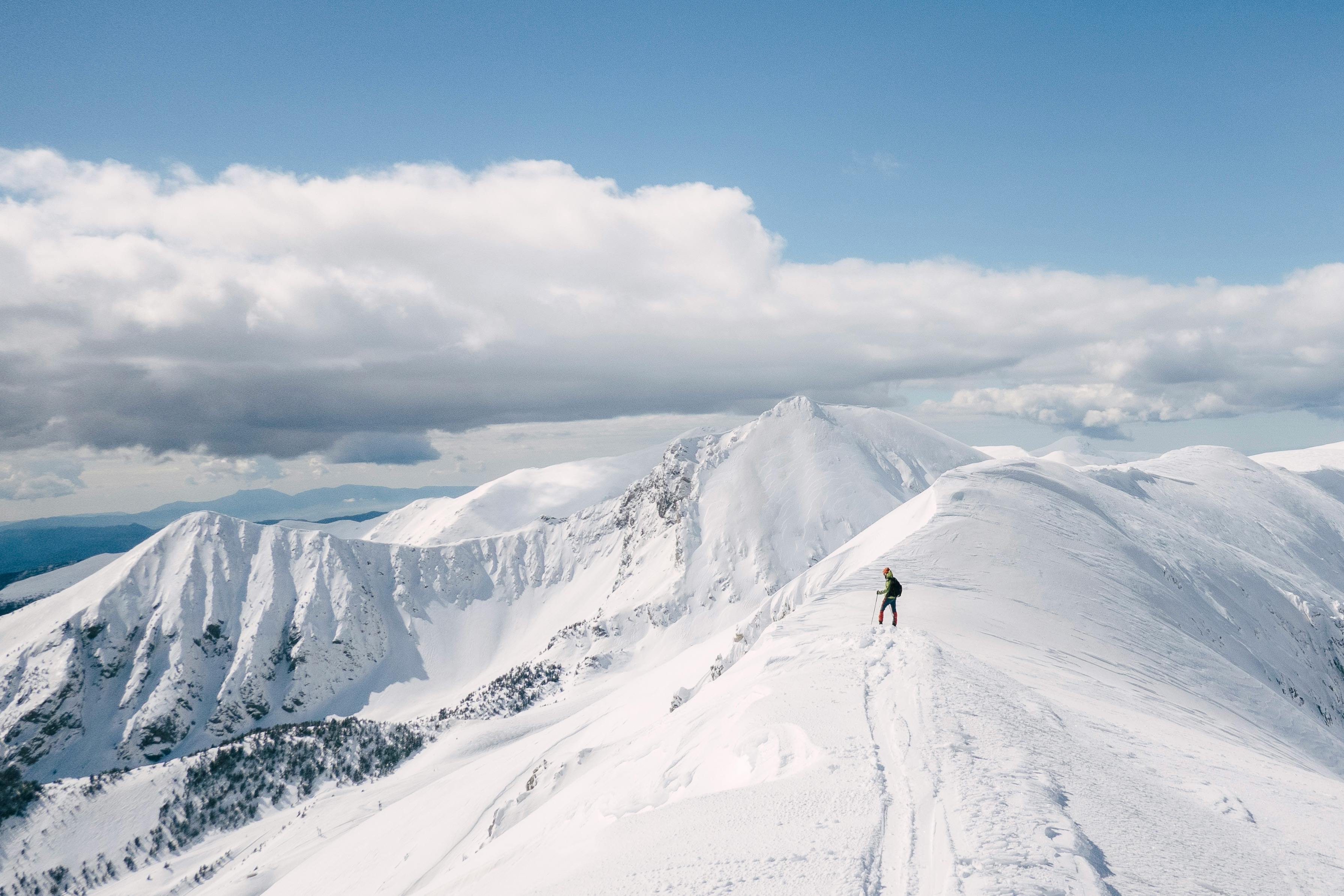 Solo Adventurer on Snowy Mountain Ridge · Free Stock Photo