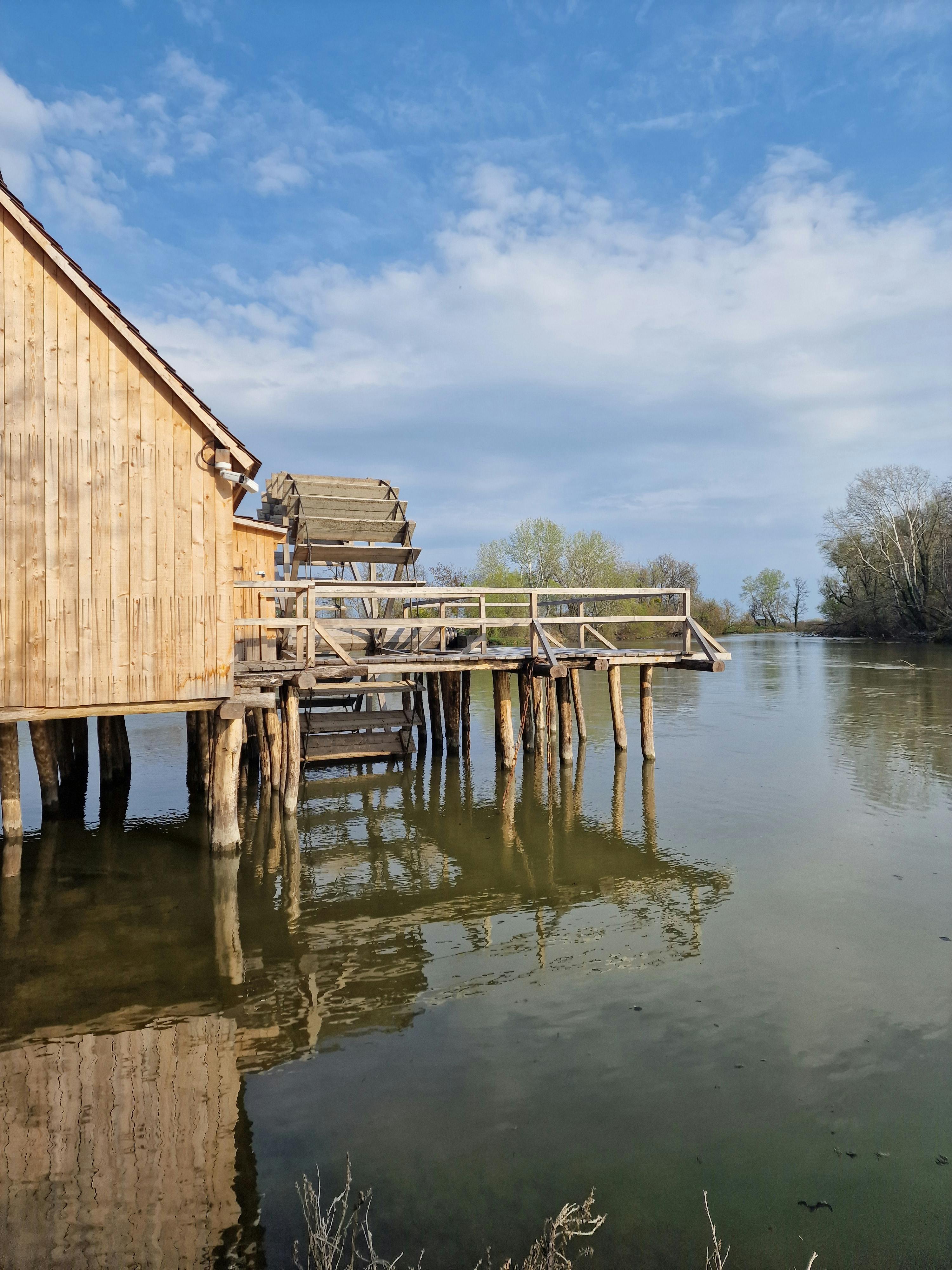 Rustic Watermill on a Serene Riverbank · Free Stock Photo