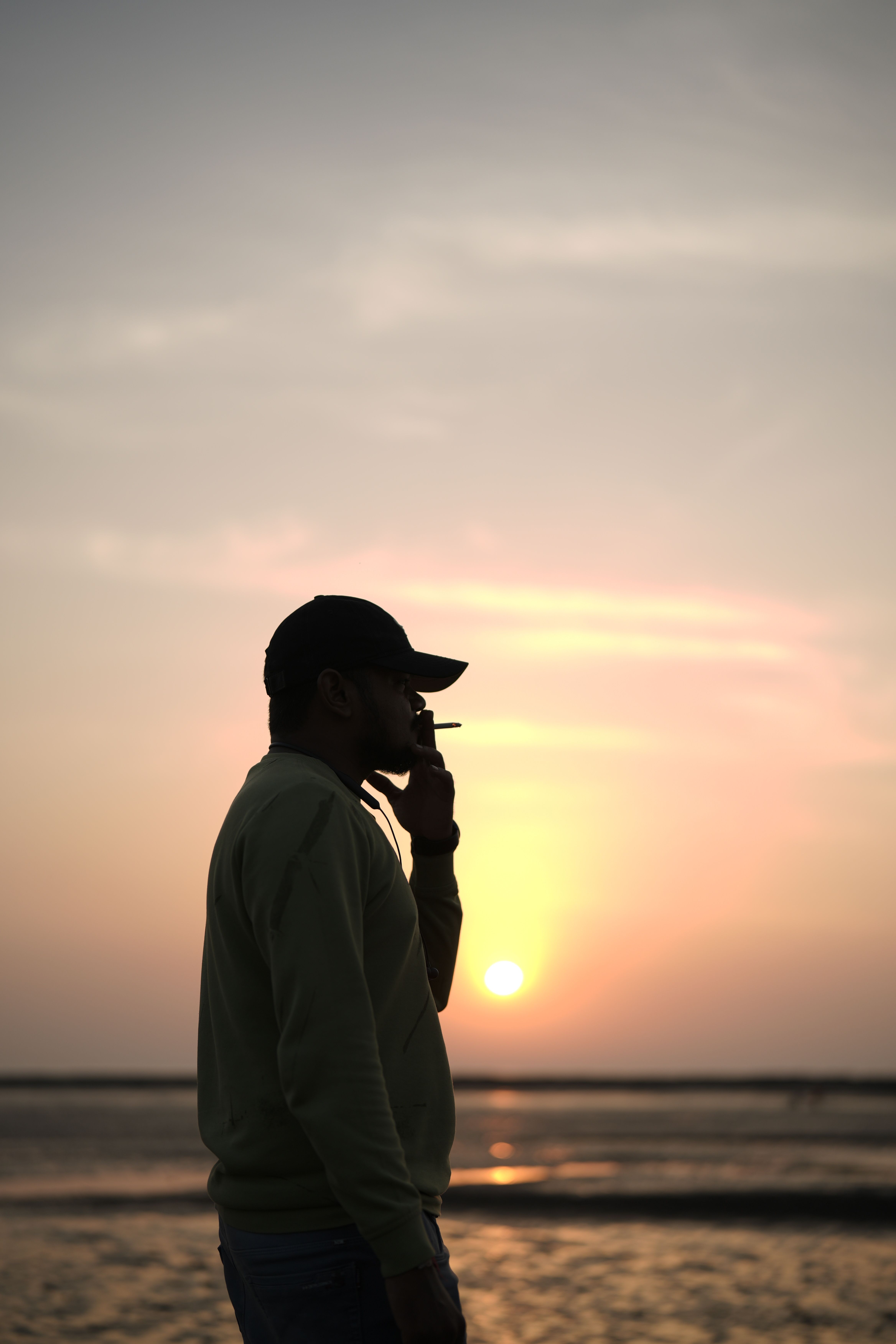 Silueta De Hombre Fumando Al Atardecer En La Playa · Foto de stock gratuita