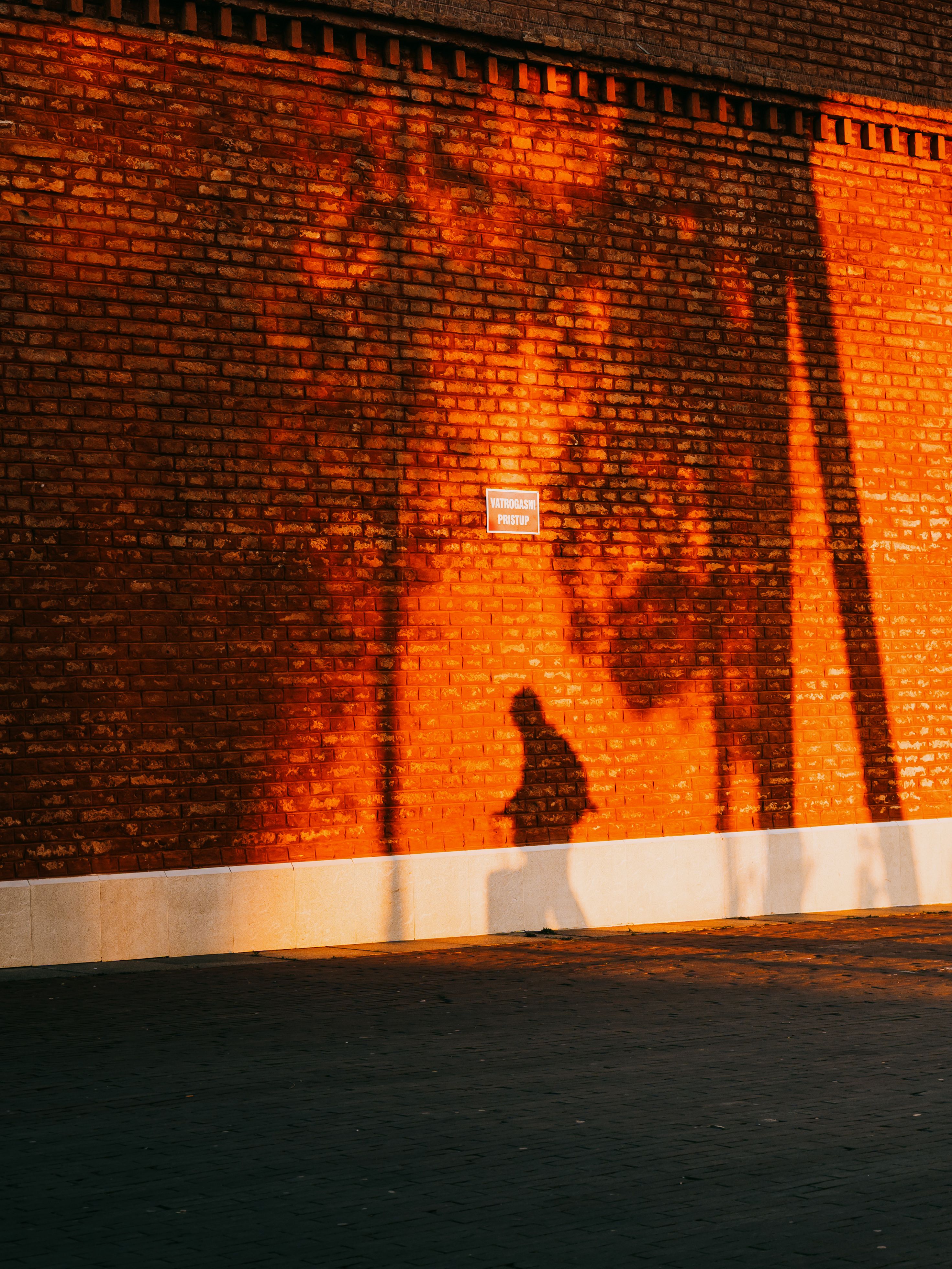 Silhouette on Brick Wall at Sunset · Free Stock Photo