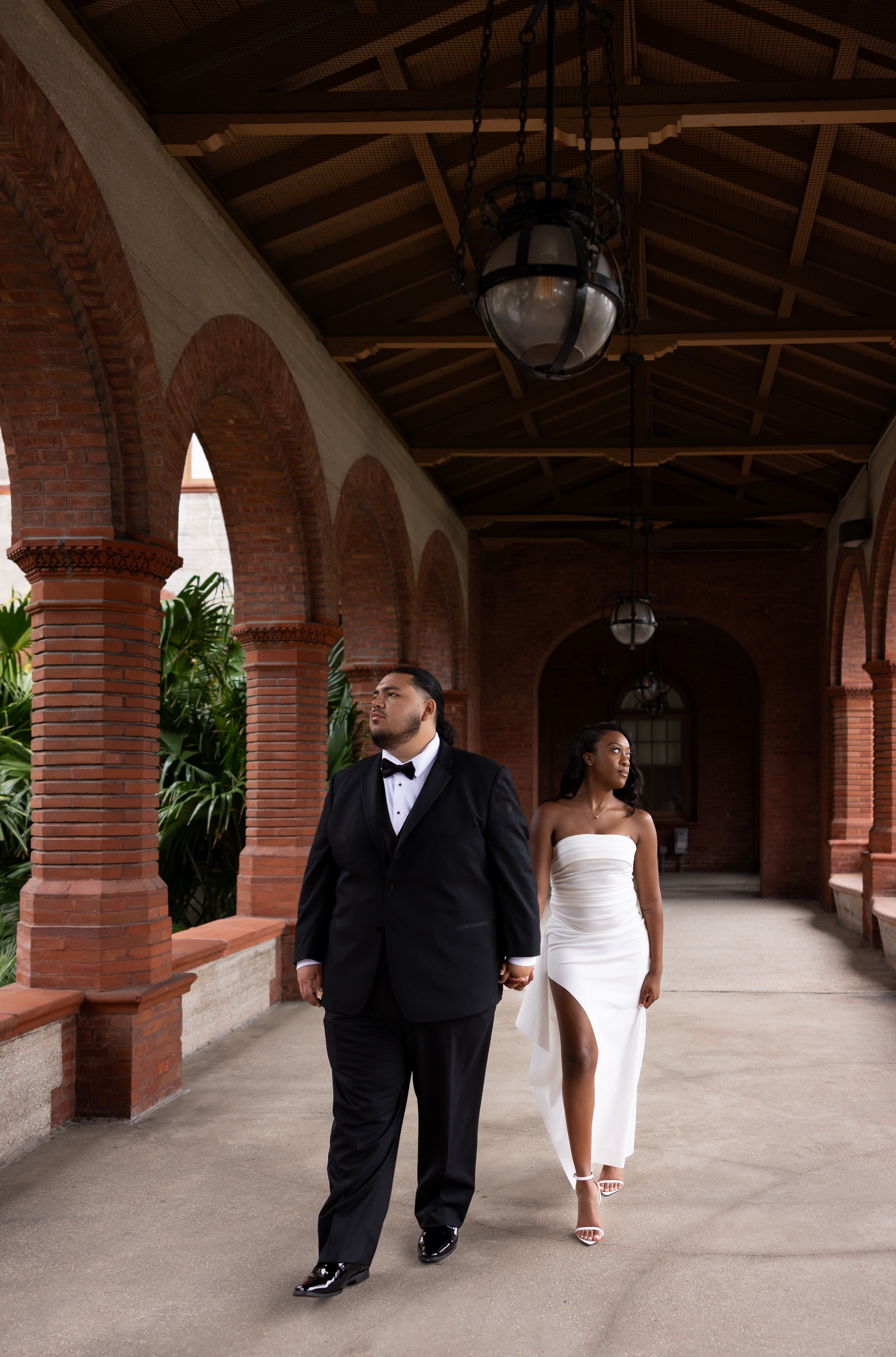 Elegant Couple Walking Through Historic Corridor · Free Stock Photo