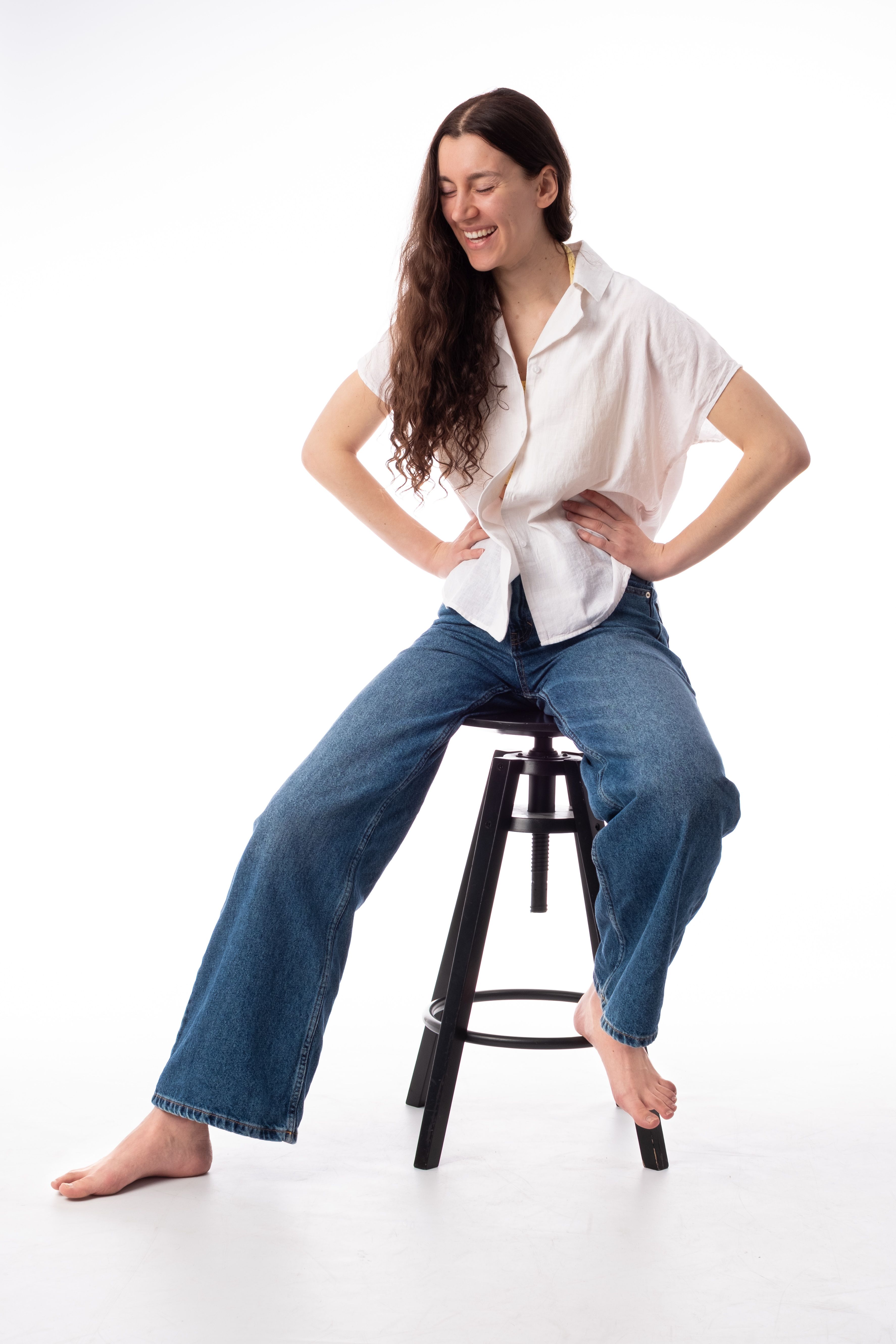 Smiling Woman Seated Casually in Minimalist Setting · Free Stock Photo