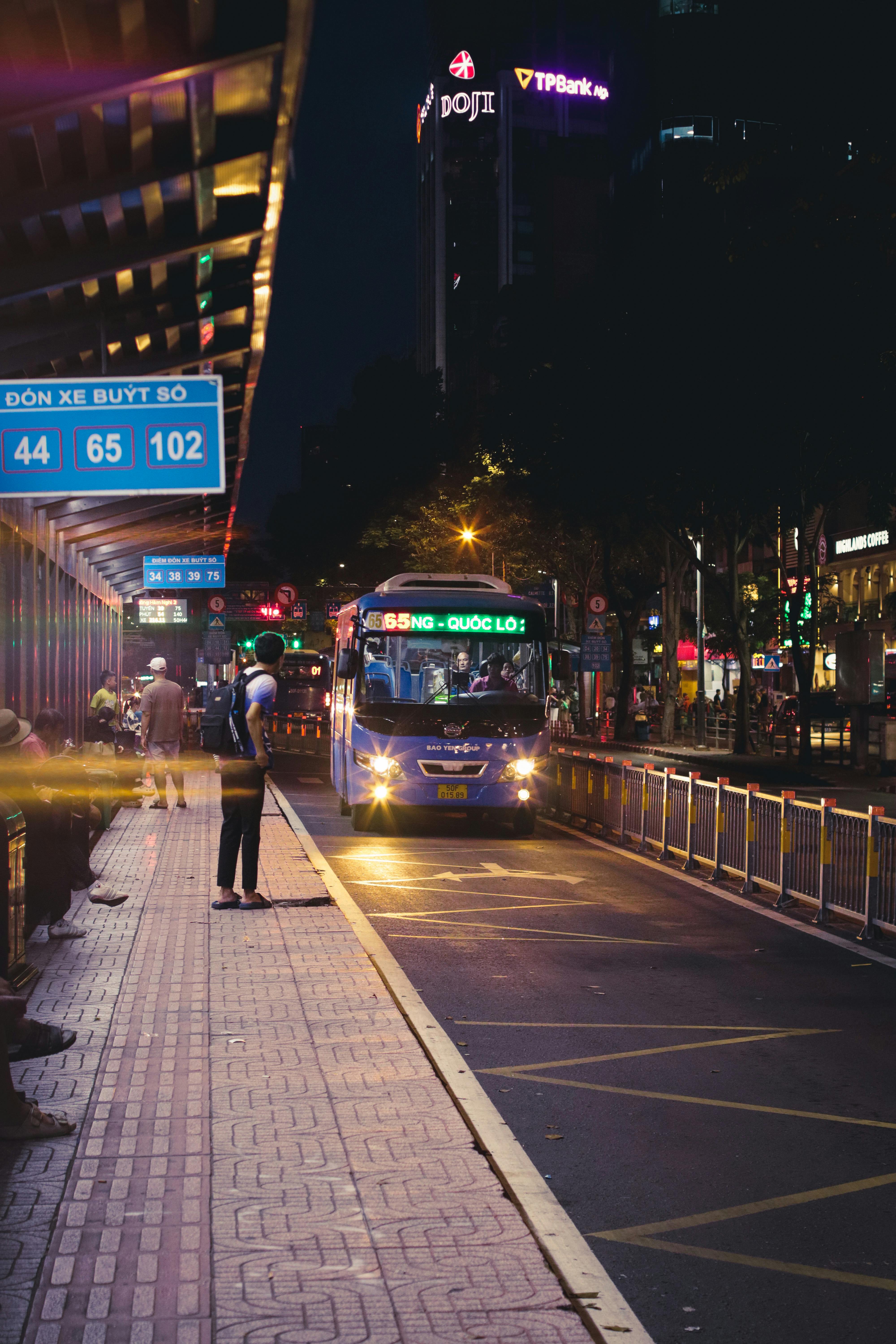 Vibrant Night Scene at Vietnamese Bus Stop · Free Stock Photo