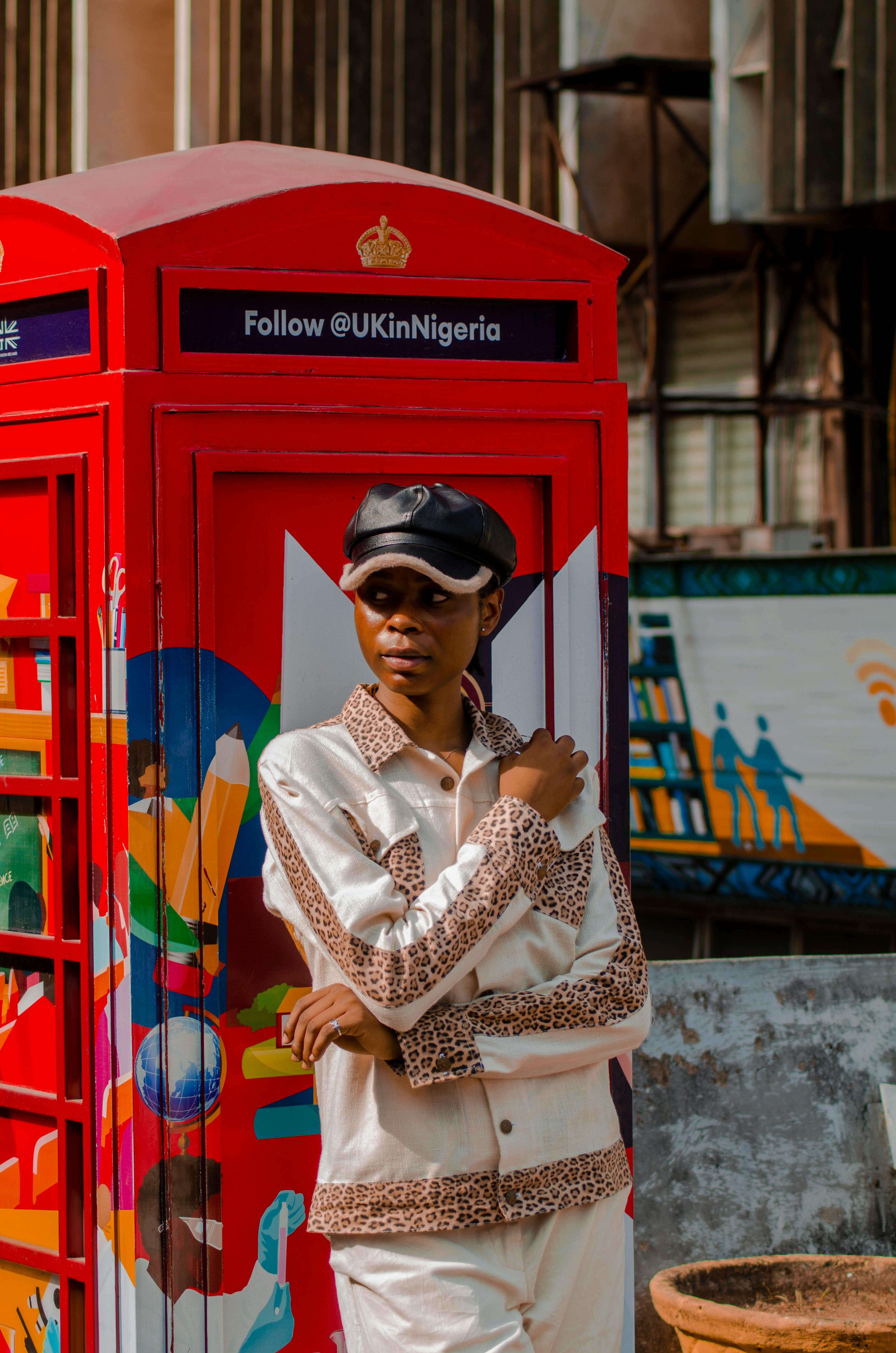 Stylishly Dressed Individual by Vibrant Phone Booth · Free Stock Photo