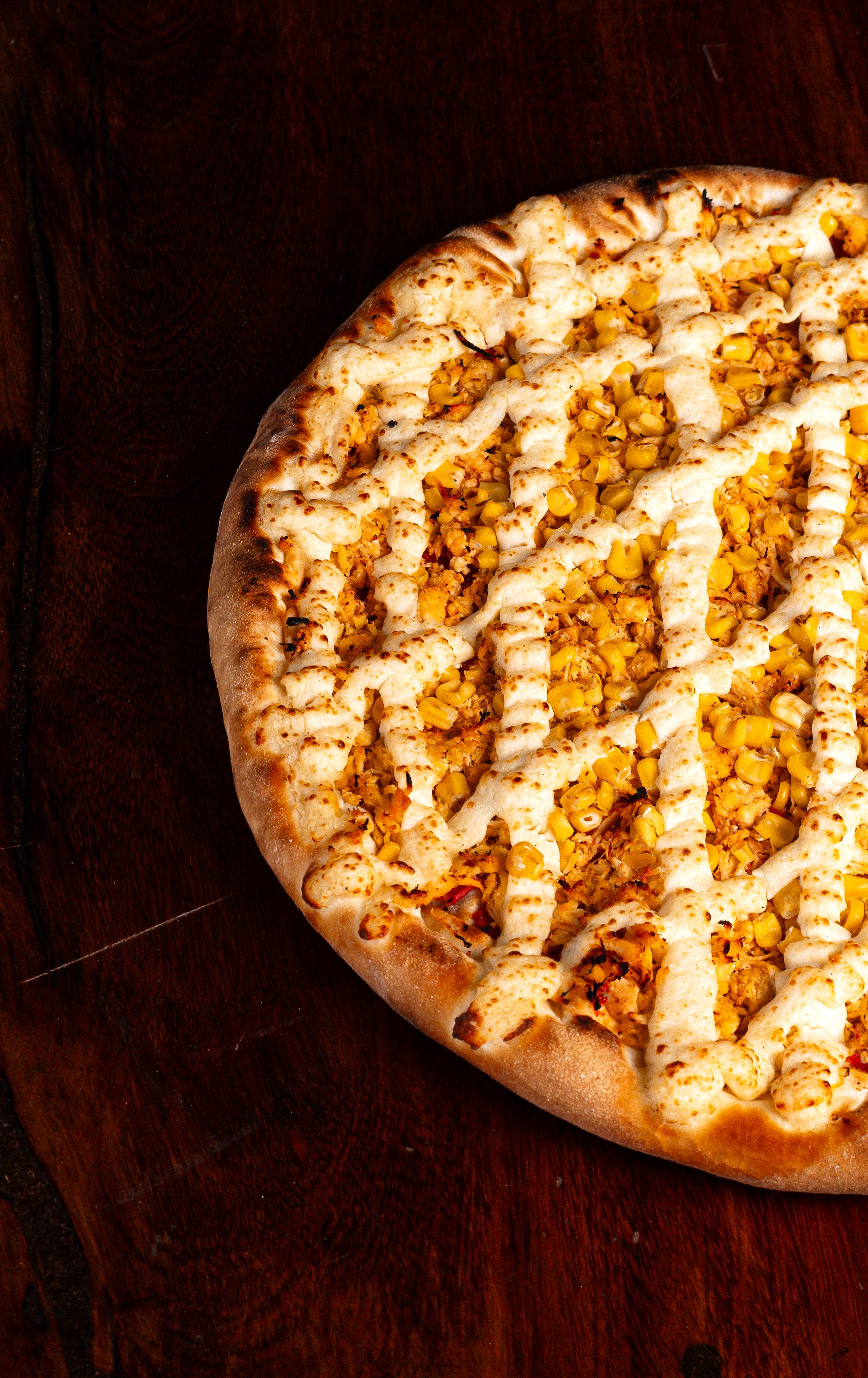 Delicious Corn and Cheese Pizza on Rustic Surface · Free Stock Photo