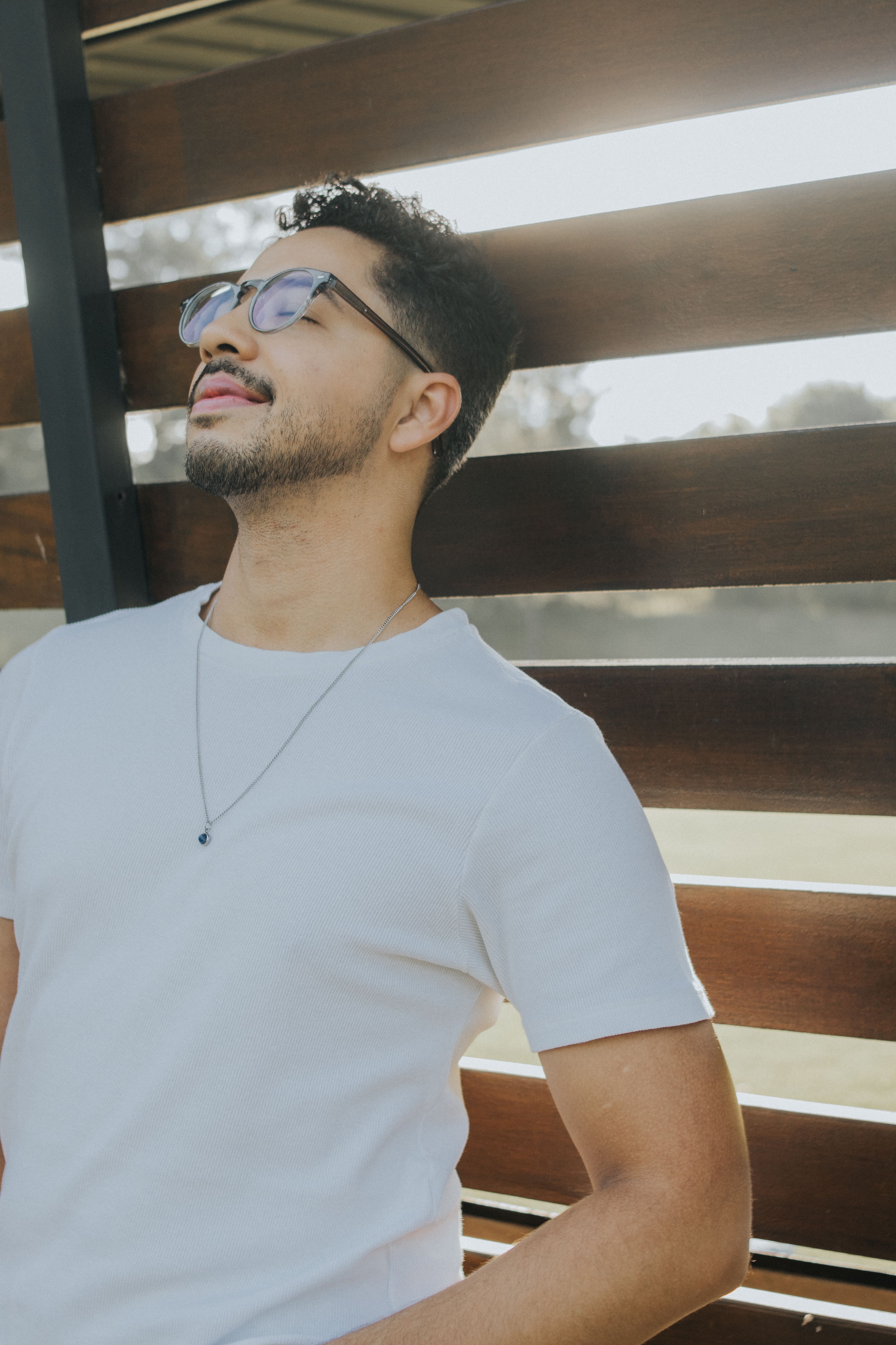 Serene Young Man Relaxing Outdoors in Sunlight · Free Stock Photo