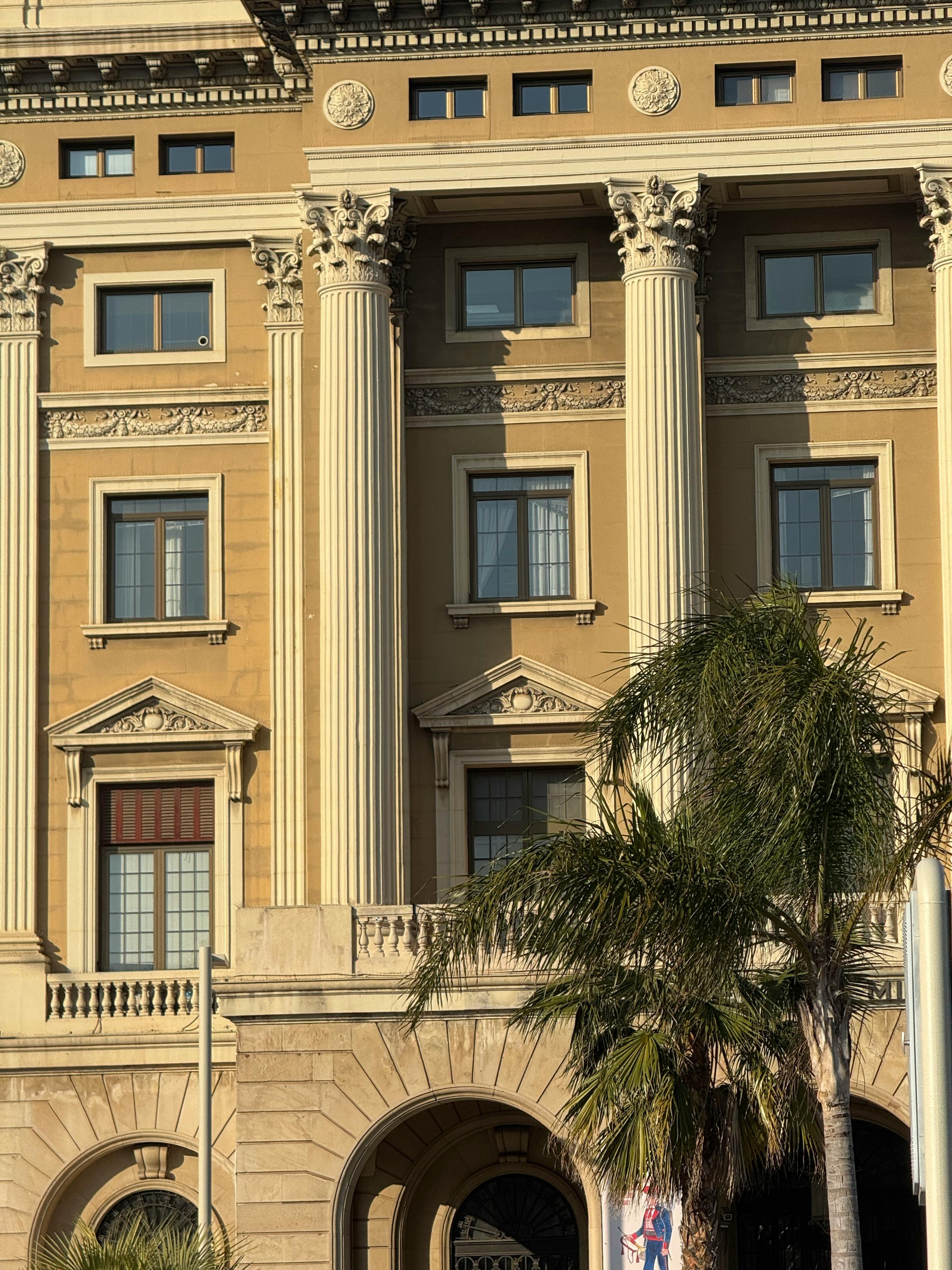 Classic Spanish Architecture with Columns and Palm · Free Stock Photo
