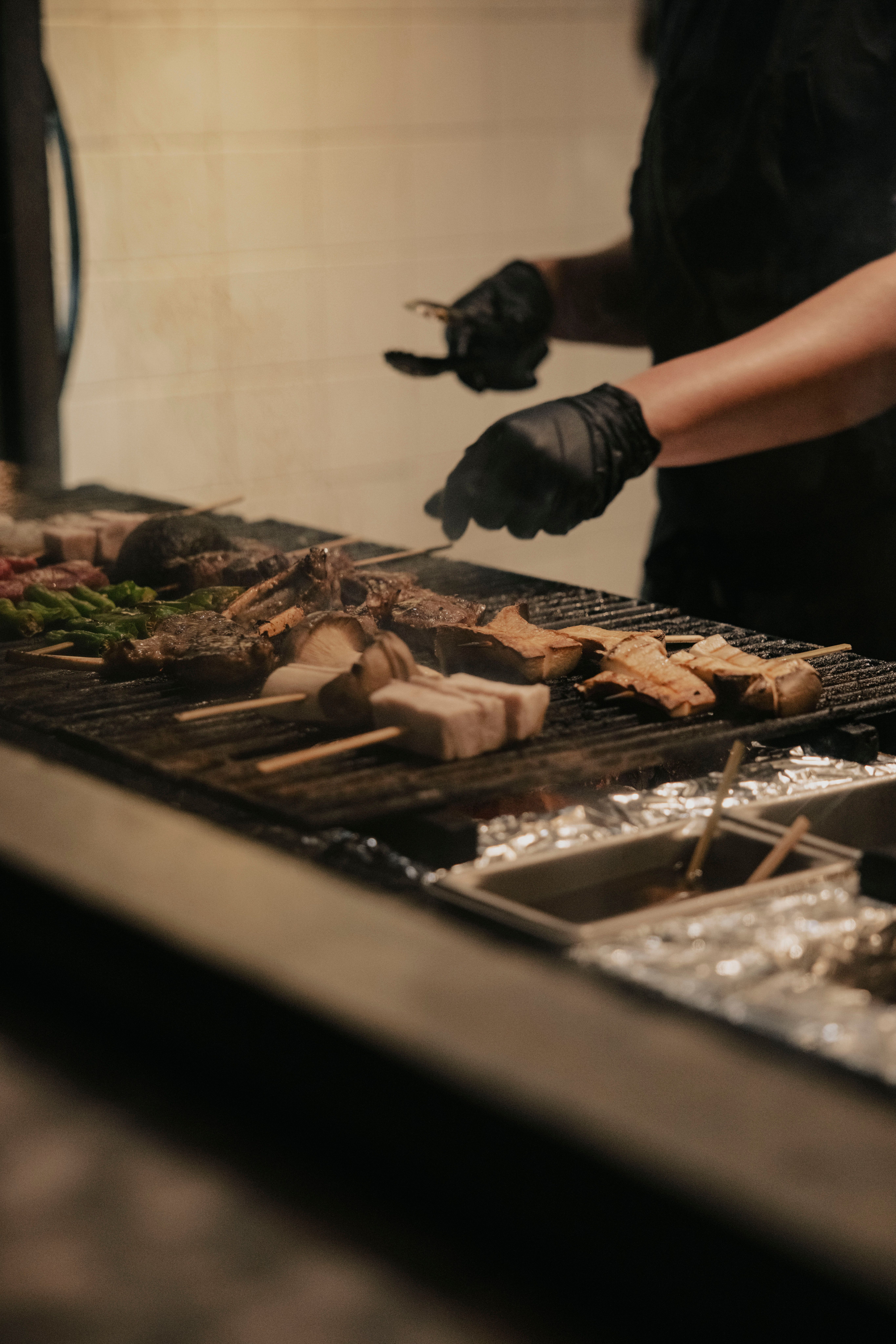 Chef Grilling Assorted Skewers Indoors · Free Stock Photo