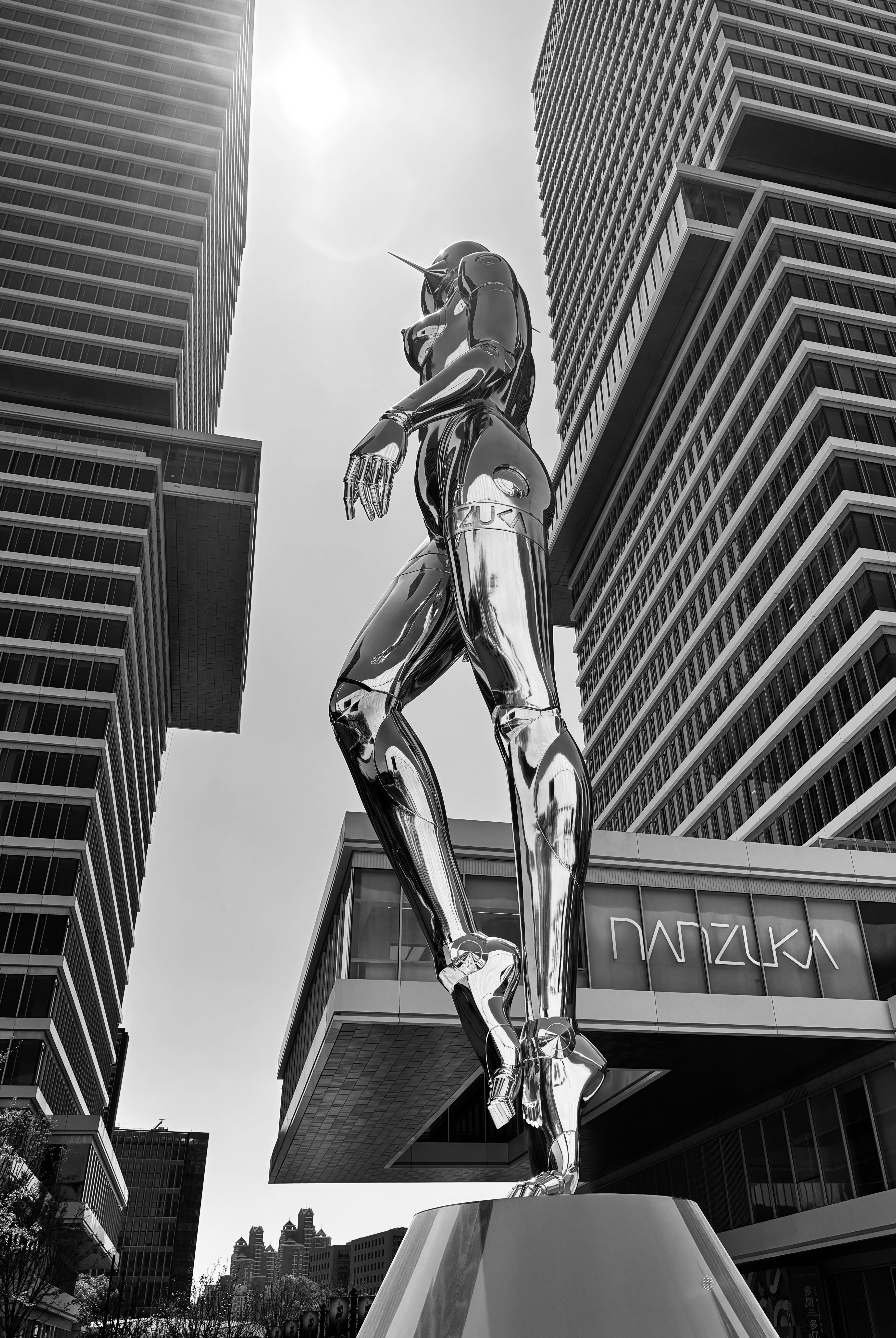 Futuristic Silver Statue Among Urban Skyscrapers · Free Stock Photo