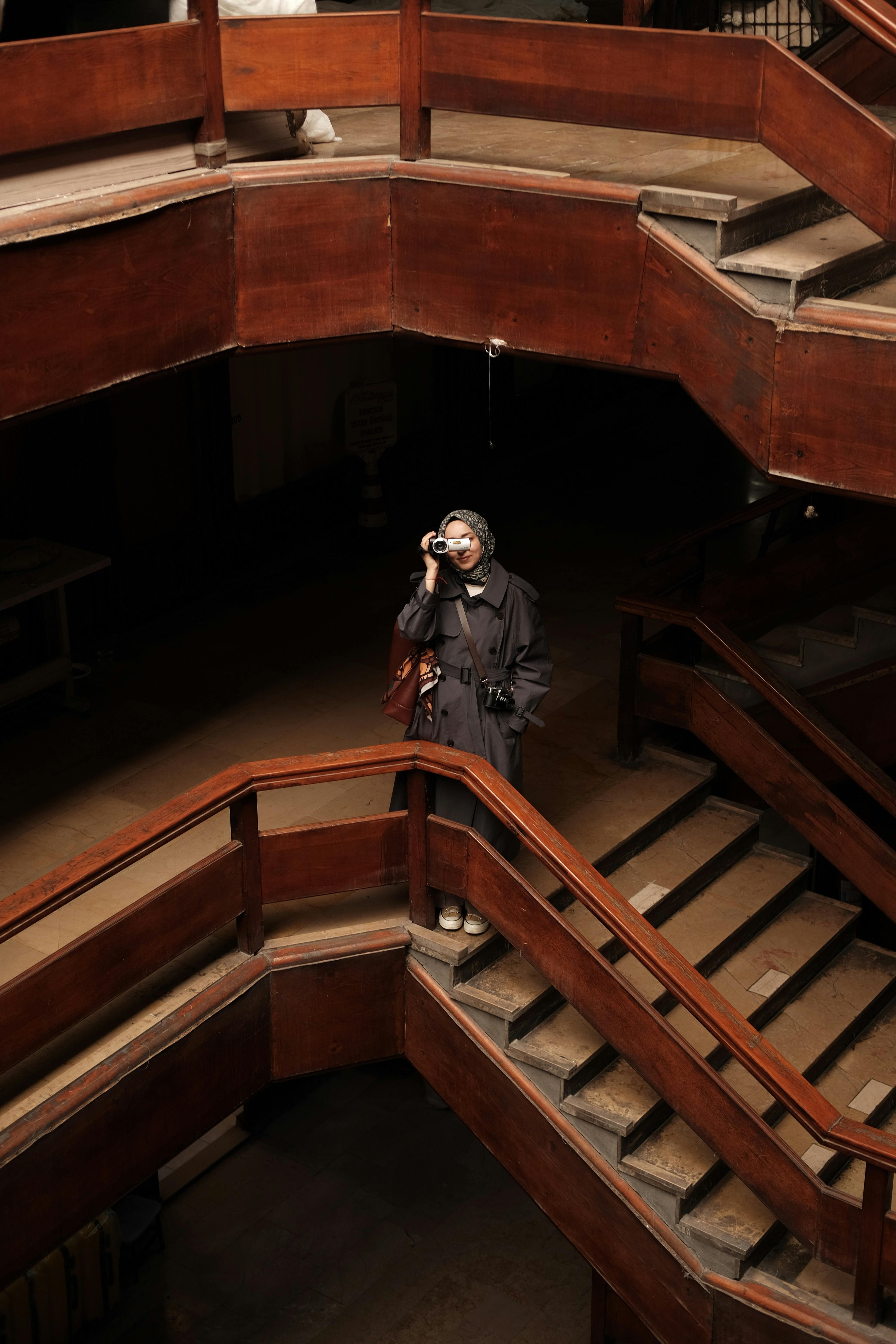 Person Exploring Vintage Wooden Staircase Indoors · Free Stock Photo