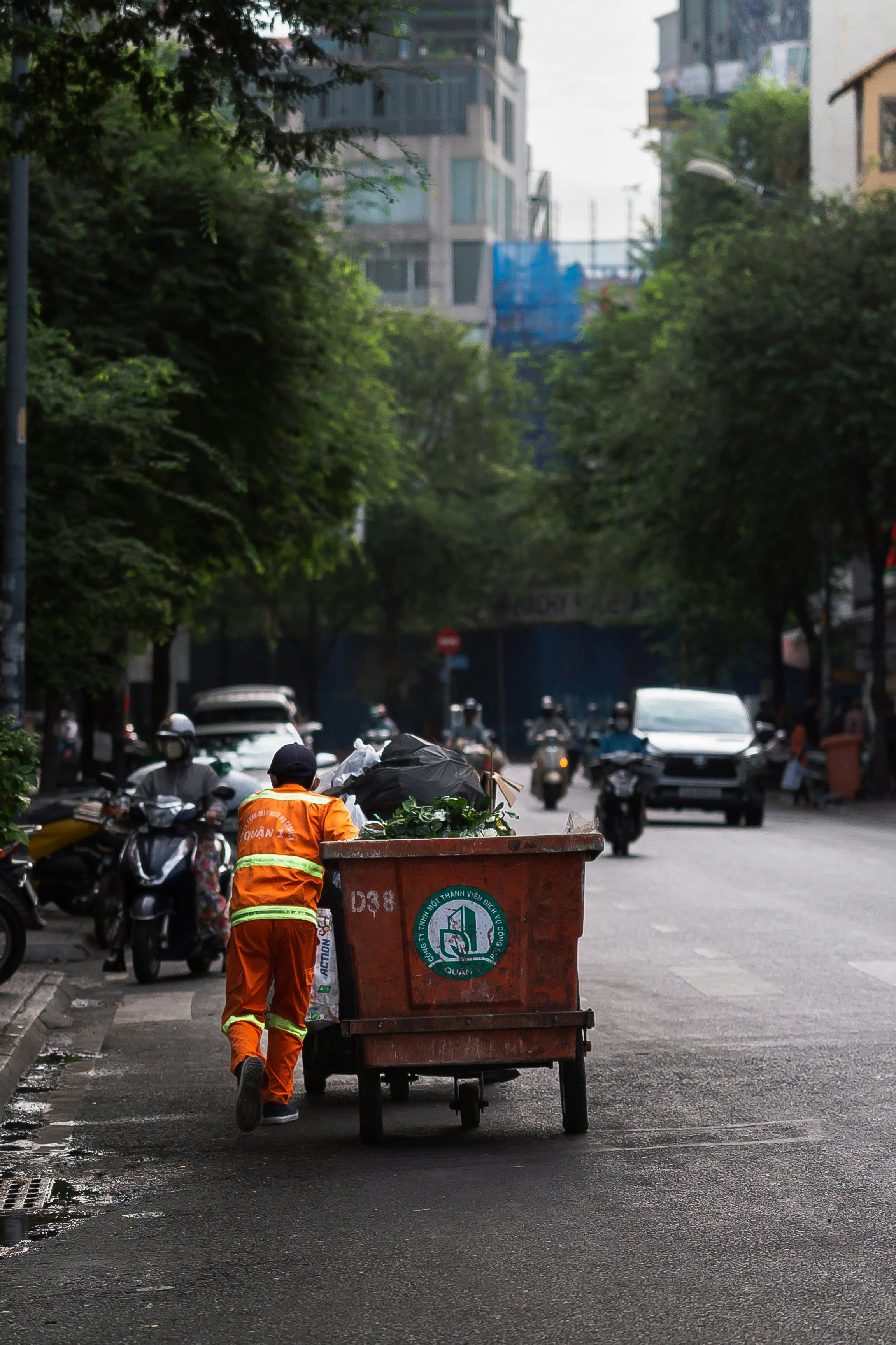 Urban Street Cleaner Pushing Garbage Bin · Free Stock Photo