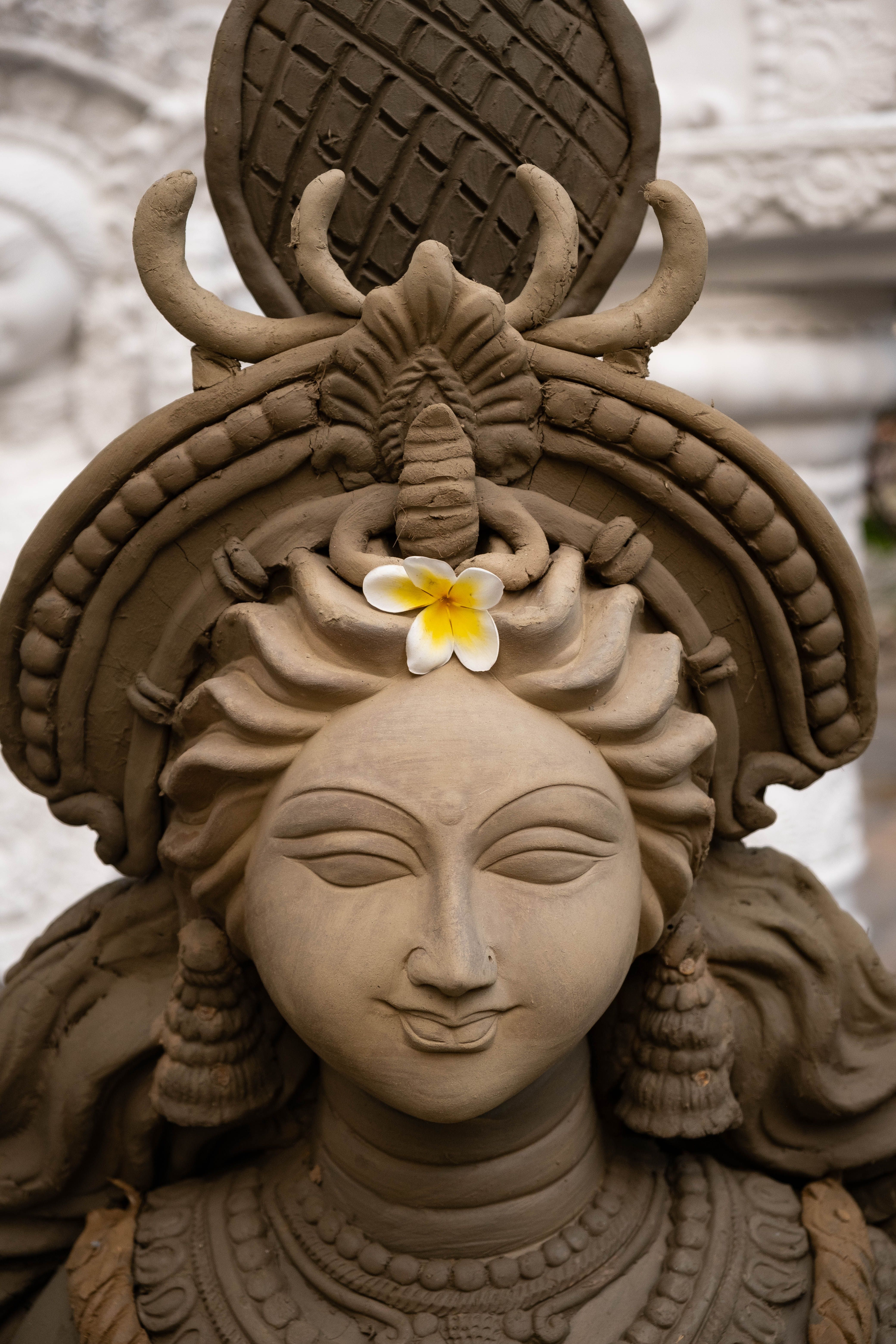 Intricate Clay Statue with Plumeria Flower · Free Stock Photo