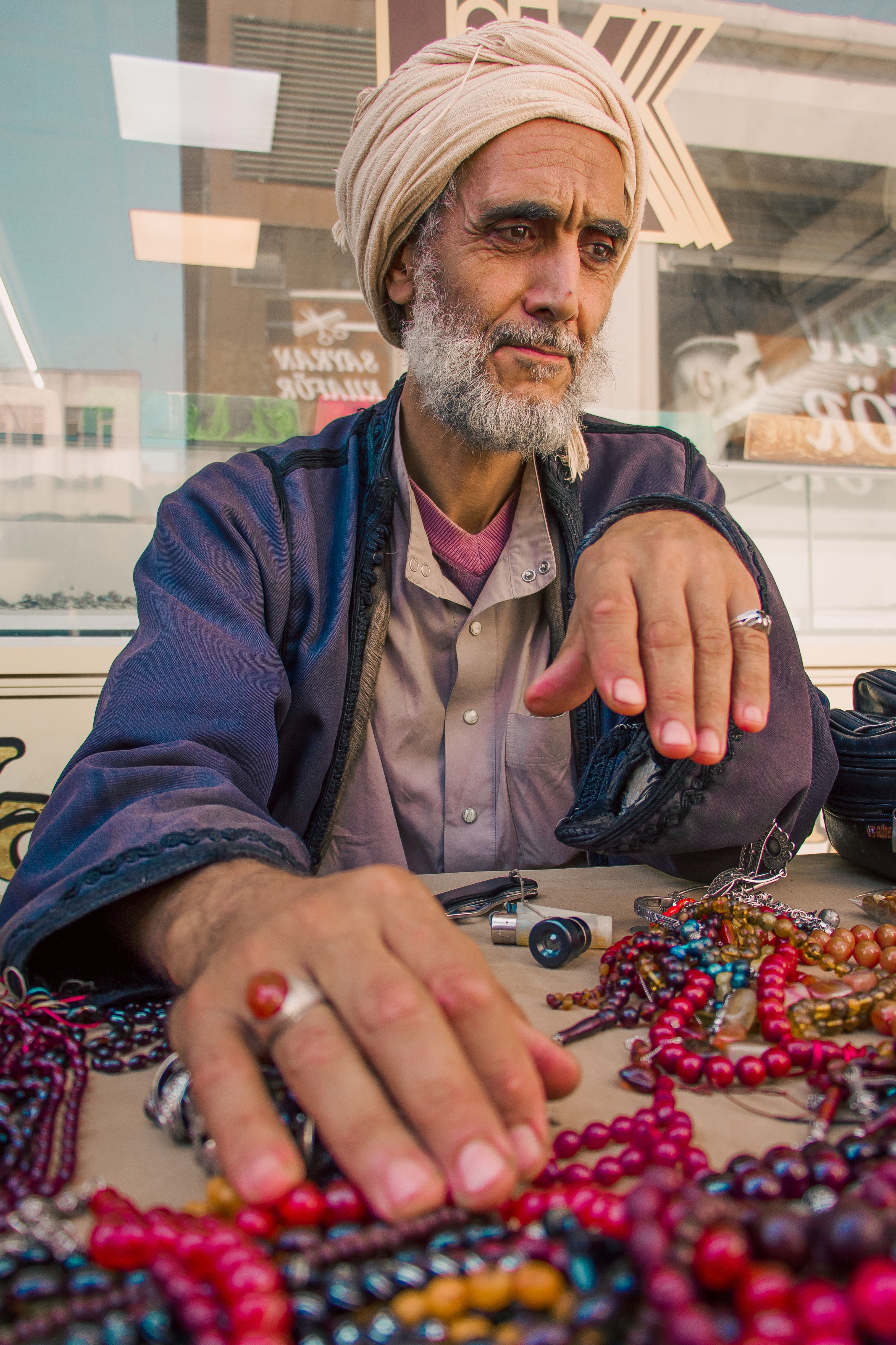 Middle Eastern Trader Displaying Colorful Beads · Free Stock Photo