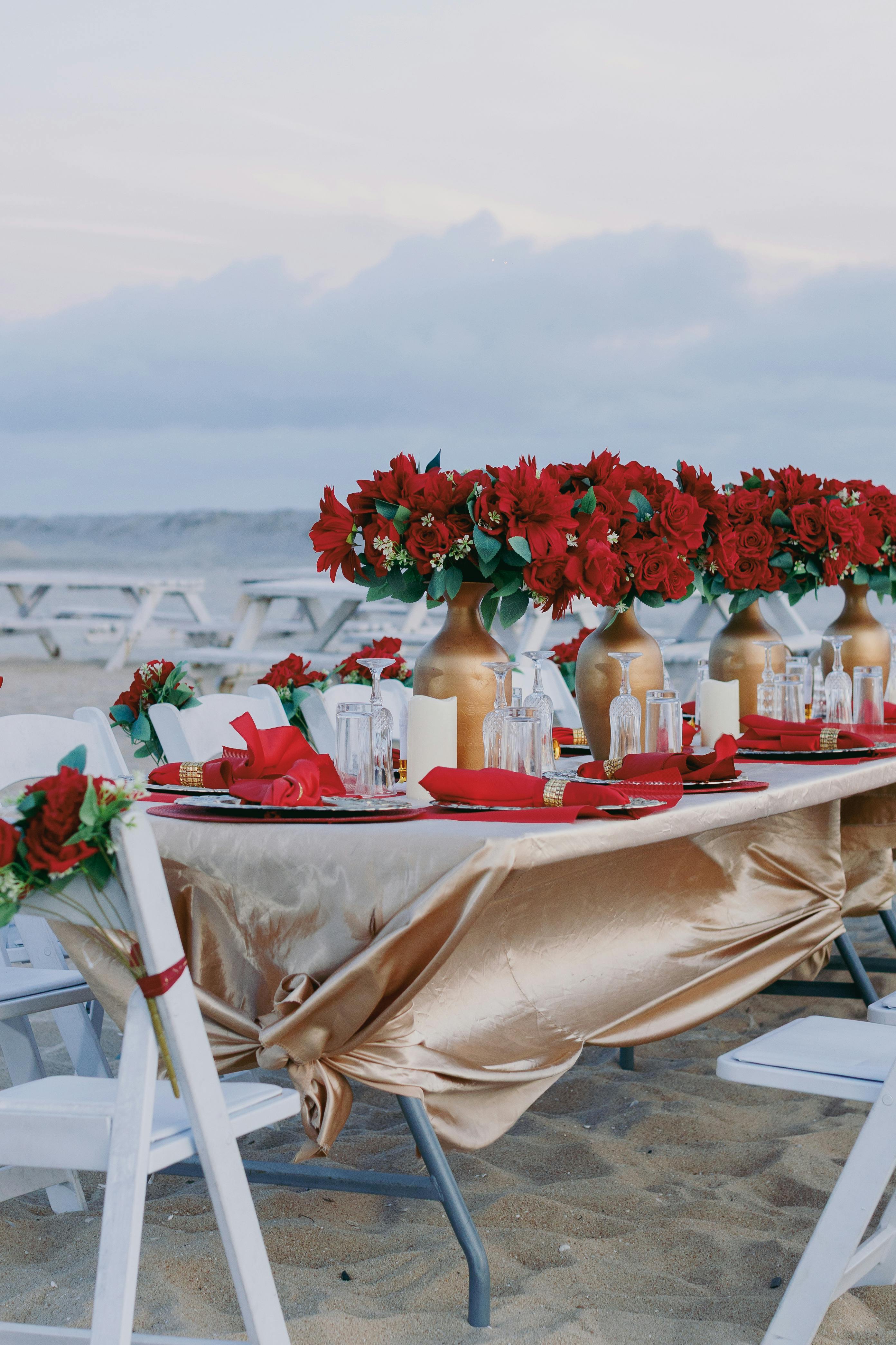 Elegant Beach Table Setting with Red Flowers · Free Stock Photo