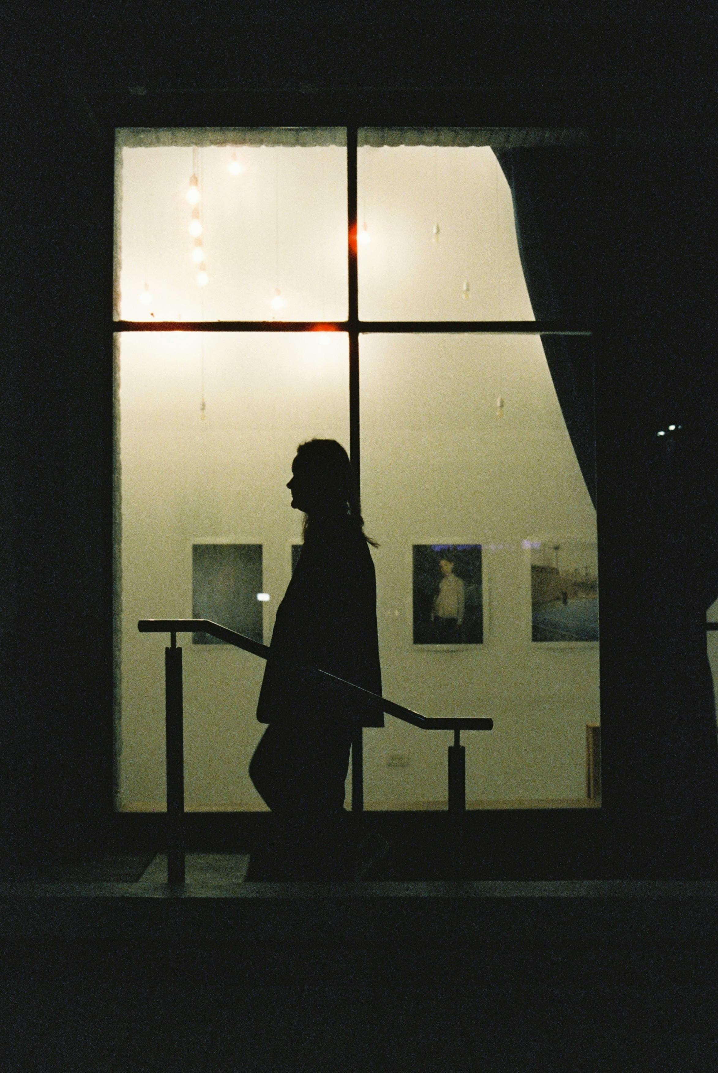 Silhouette of Person at Night by Gallery Window · Free Stock Photo