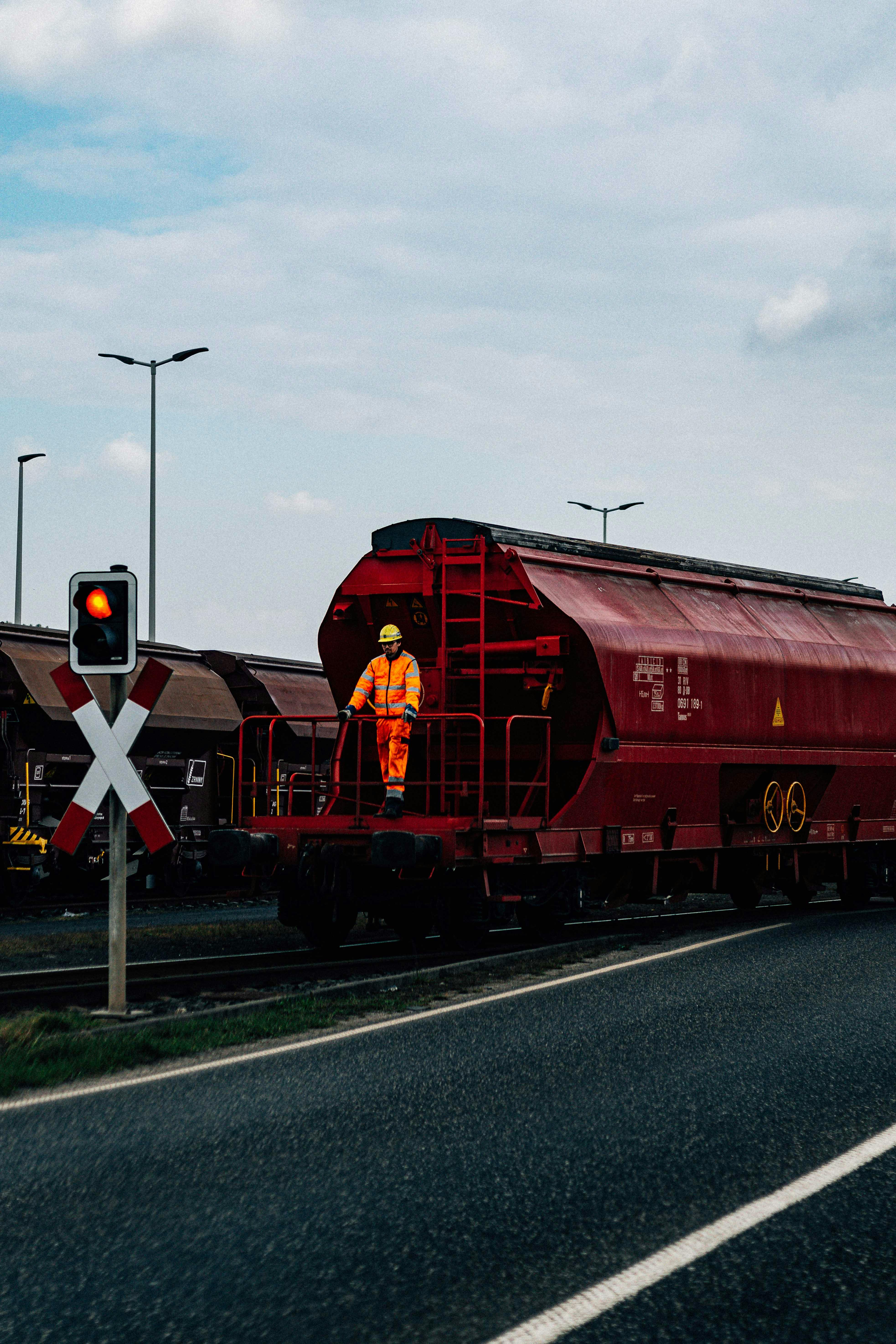 Red Freight Train with Worker on Railway Crossing · Free Stock Photo
