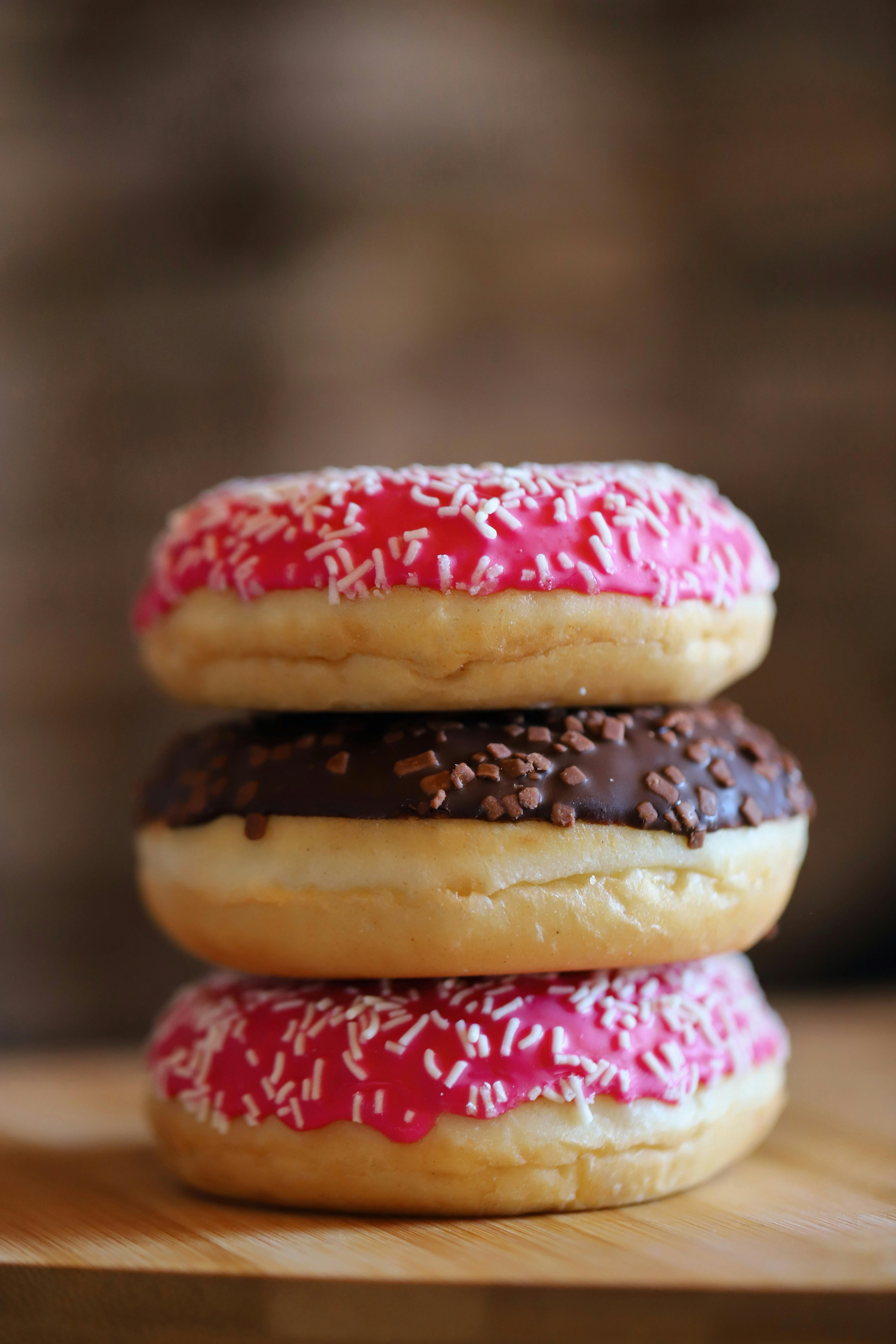 Stack of Colorful Iced Doughnuts with Sprinkles · Free Stock Photo