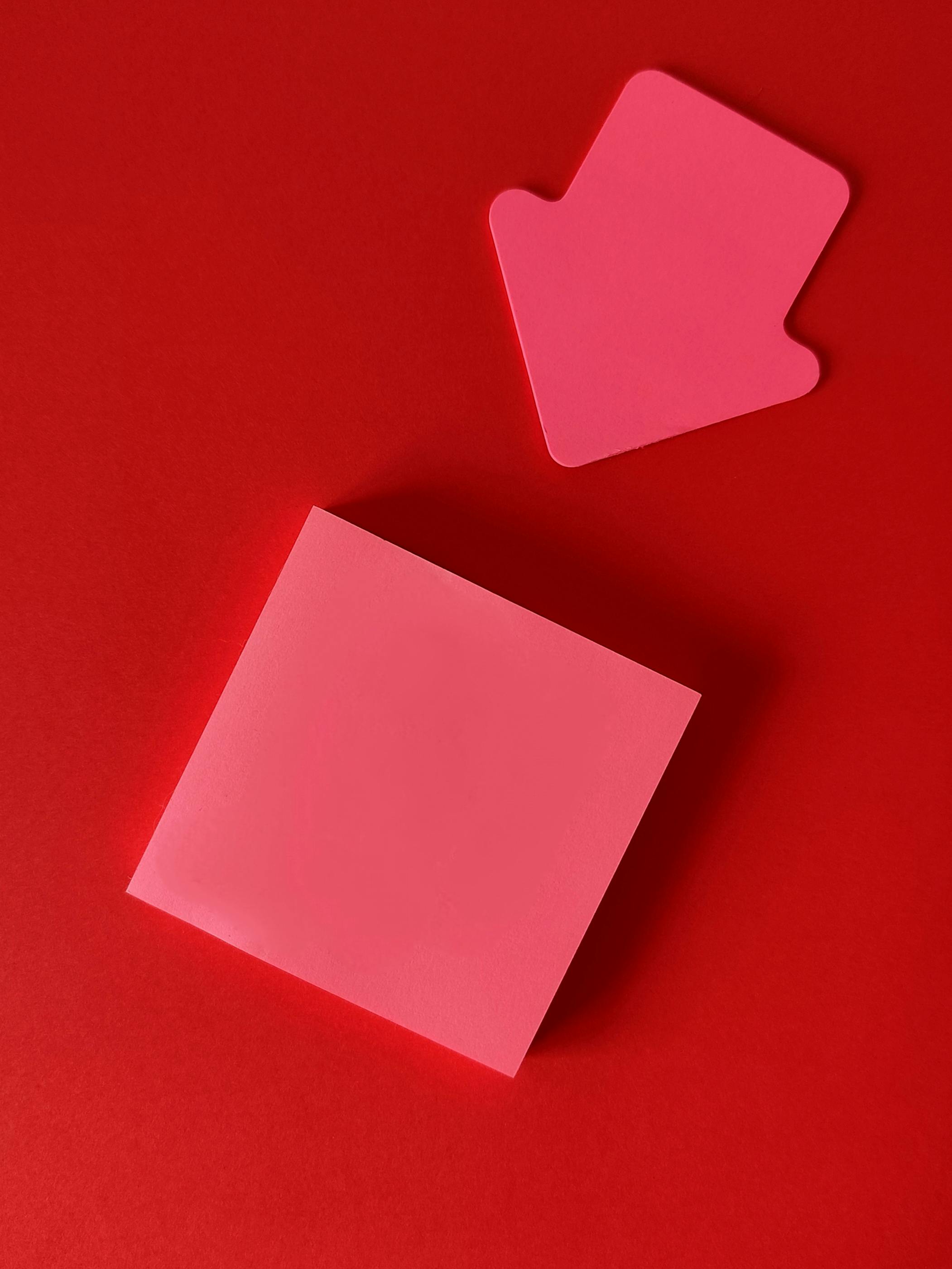 Pink Arrow and Note on Red Background · Free Stock Photo
