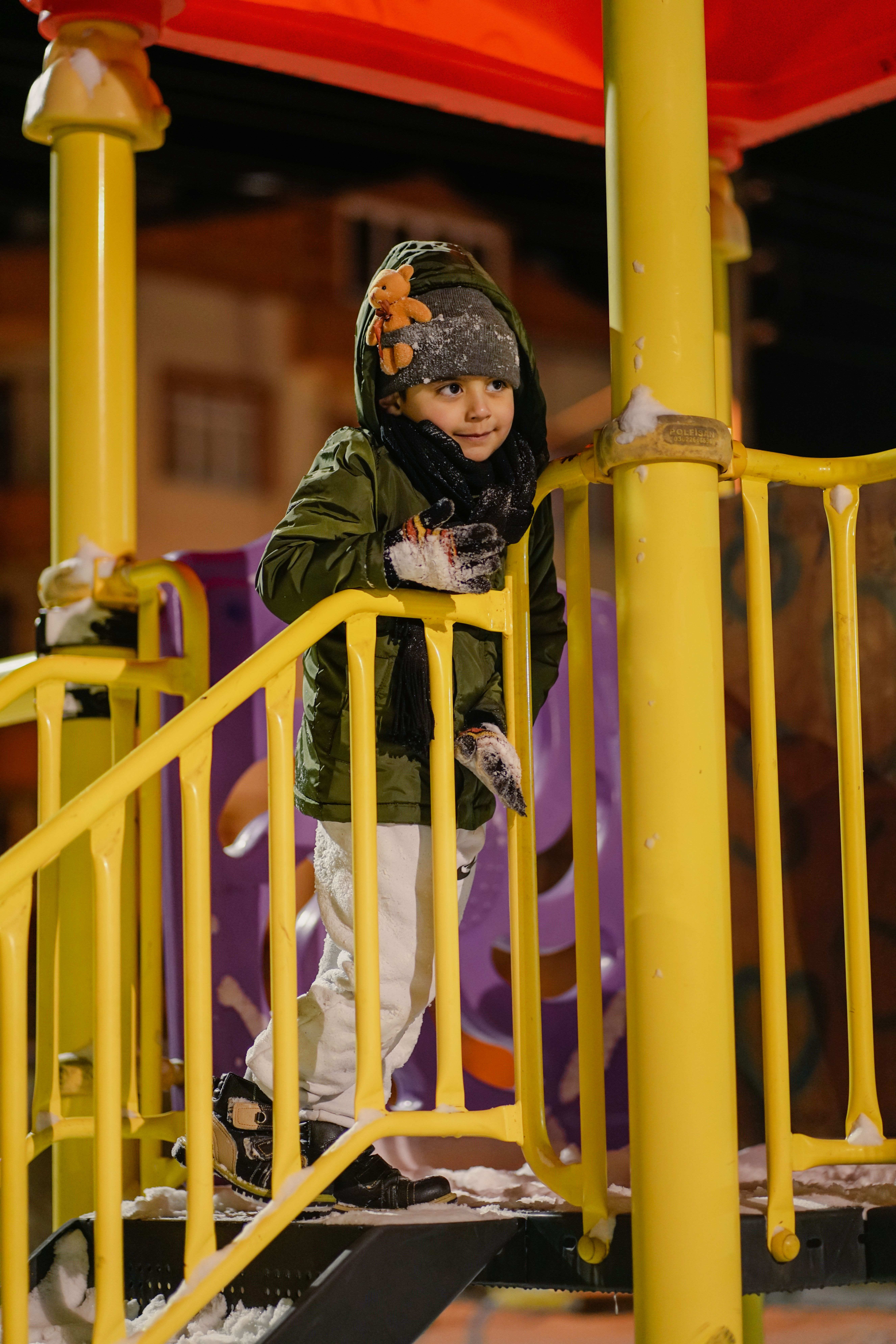 Child Playing on Snowy Playground at Night · Free Stock Photo