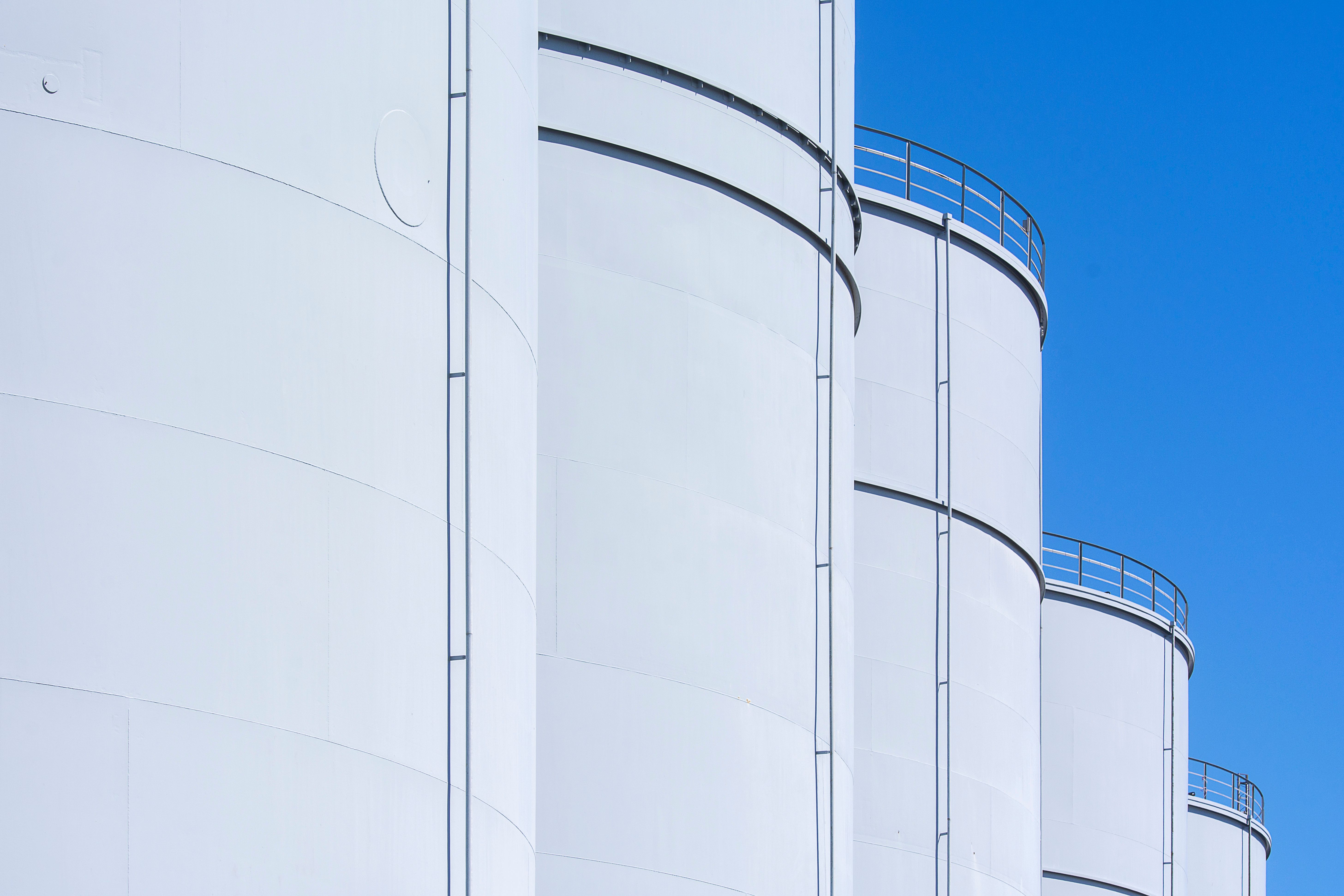 Industrial Storage Tanks Against Clear Blue Sky · Free Stock Photo