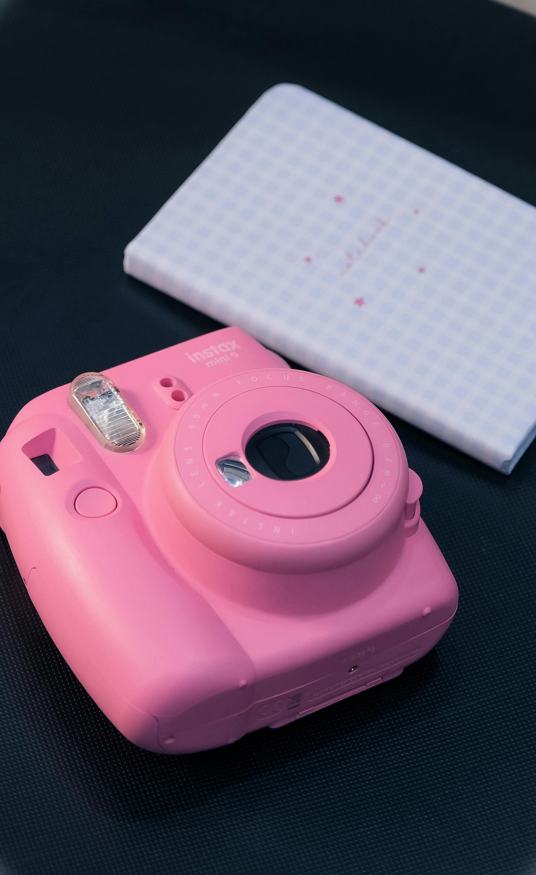 Pink Instant Camera with Notebook on Dark Surface · Free Stock Photo