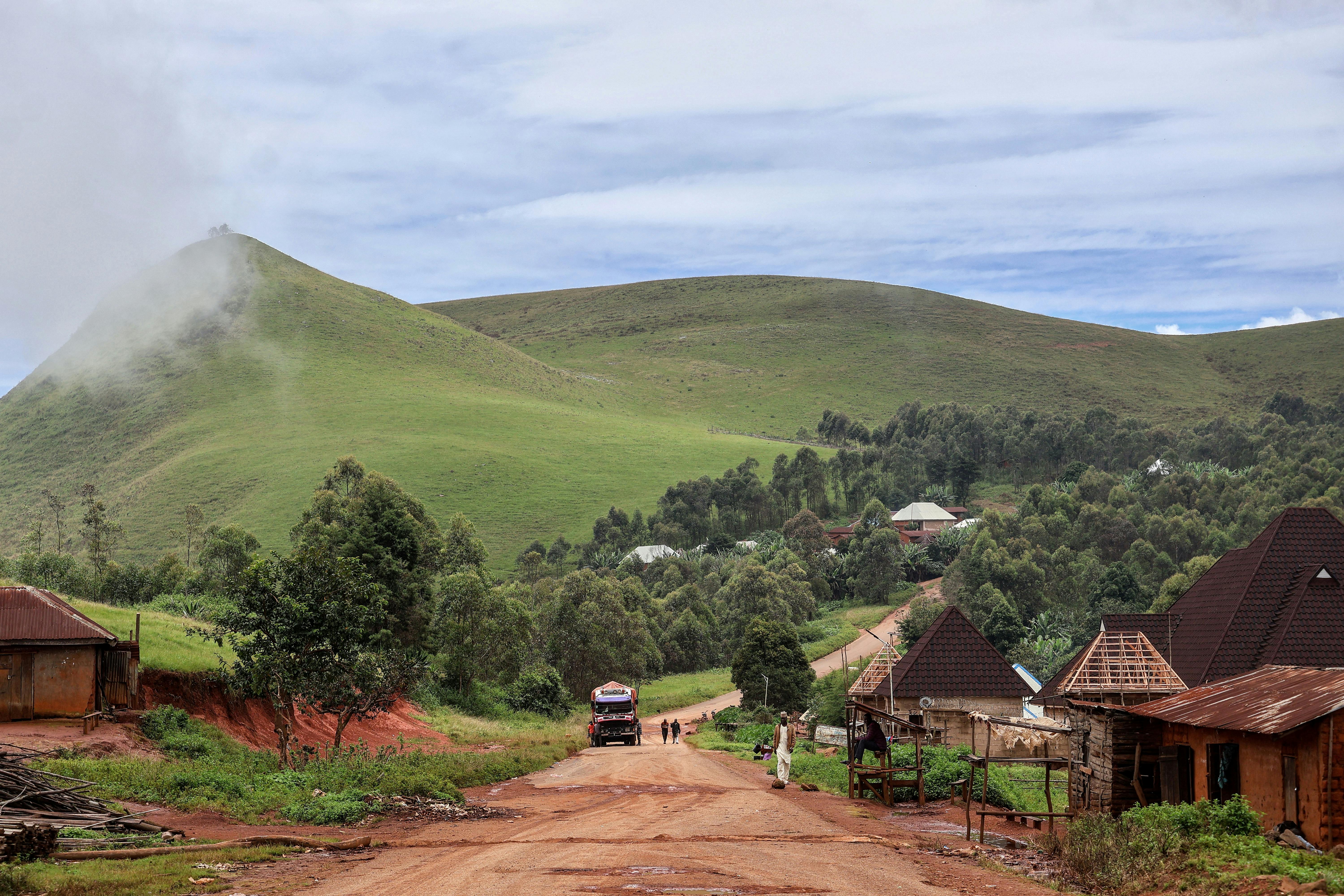 Scenic Rural Village Landscape with Green Hills · Free Stock Photo