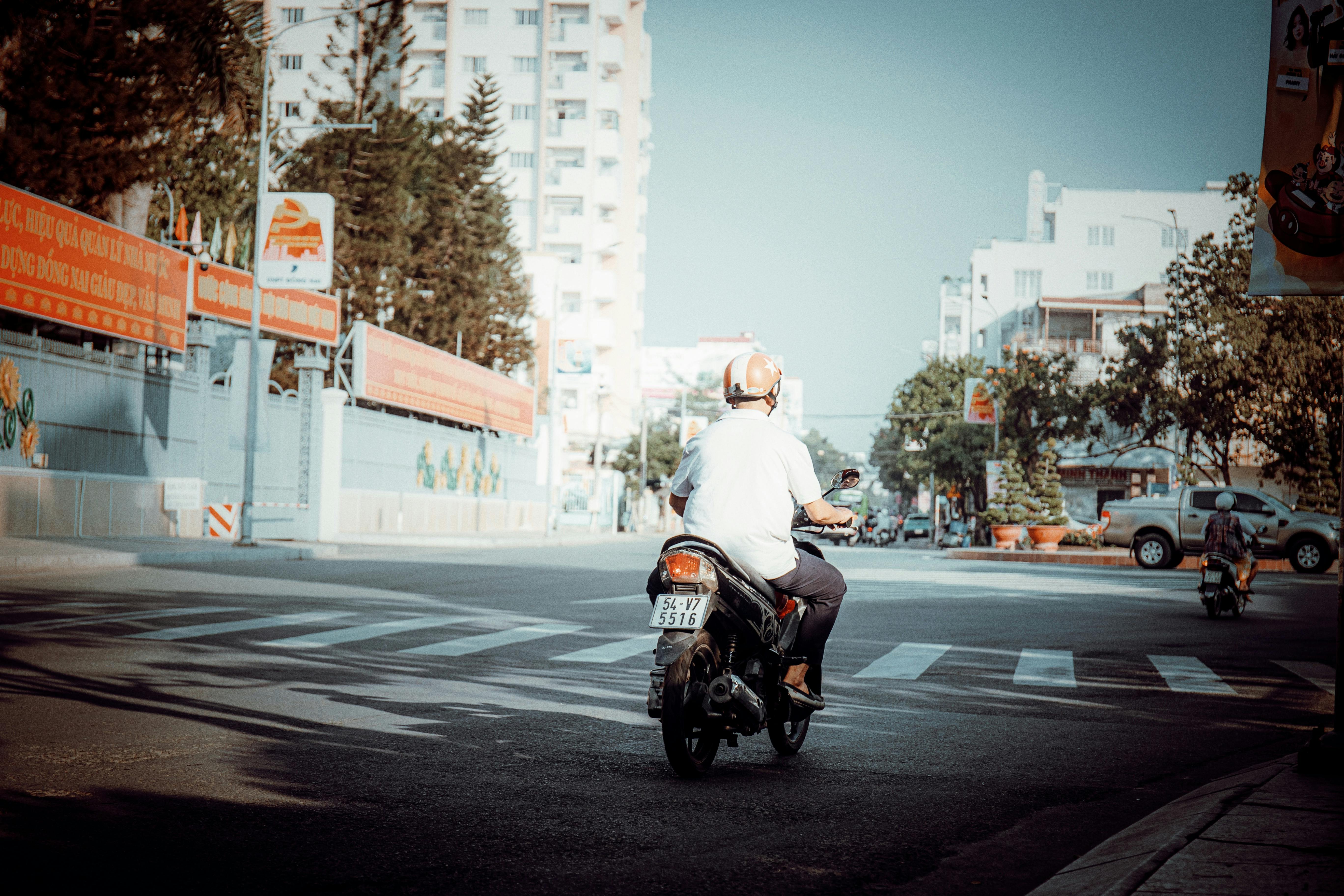 Motorcyclist Riding Through Urban Crosswalk · Free Stock Photo