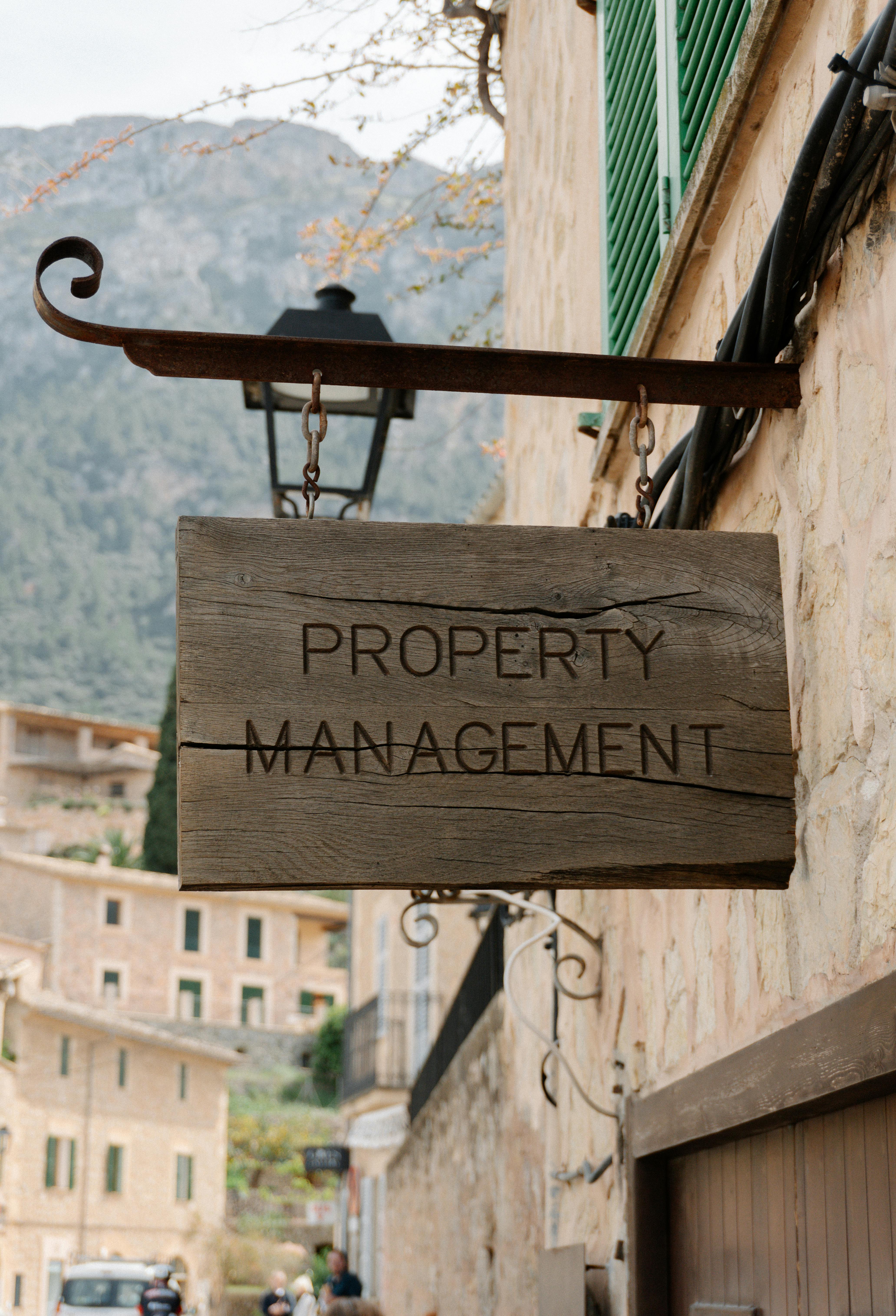 Rustic Property Management Sign in Quaint Village · Free Stock Photo