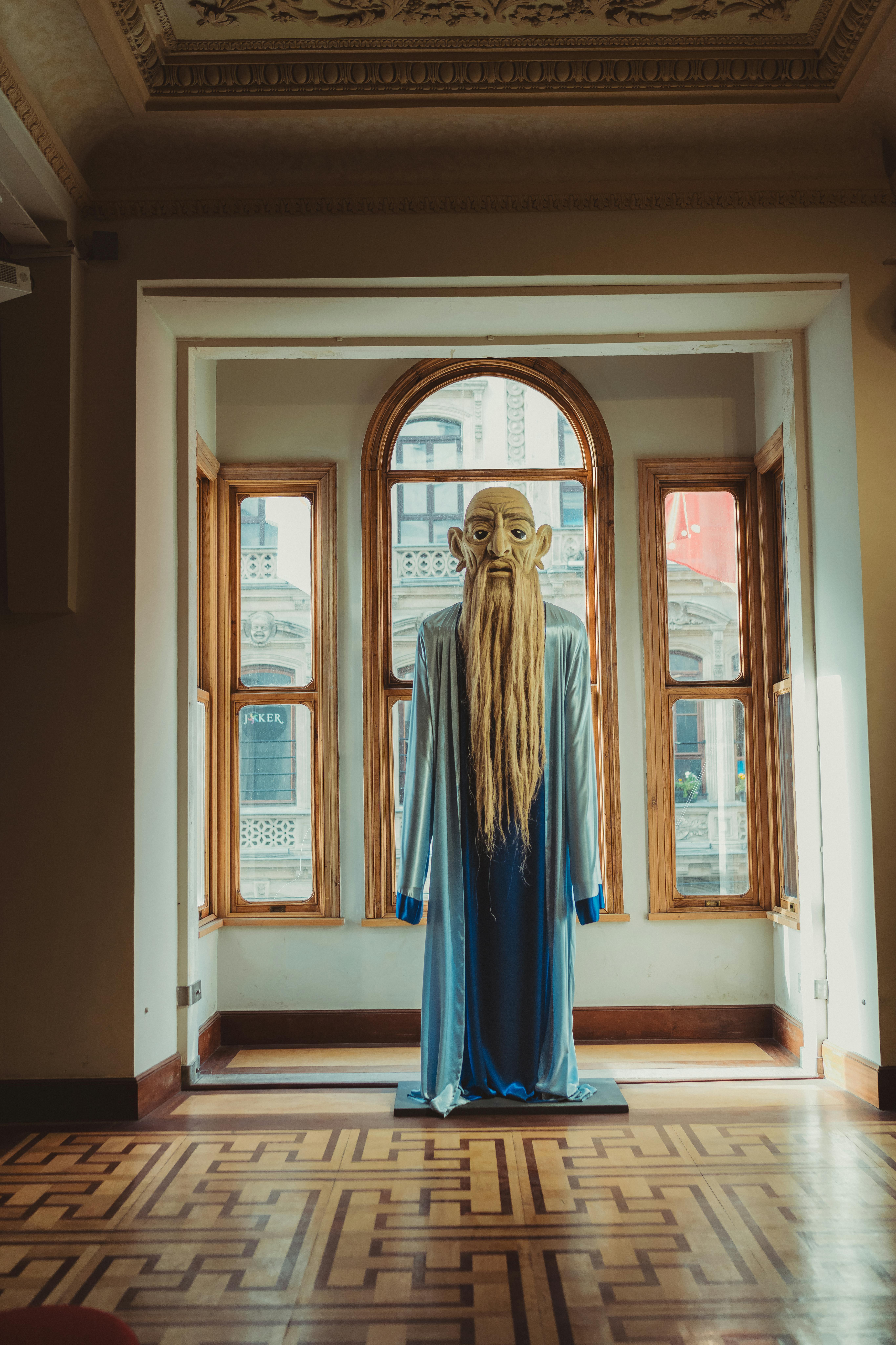 Tall Wizard Statue in Elegant Hallway Setting · Free Stock Photo