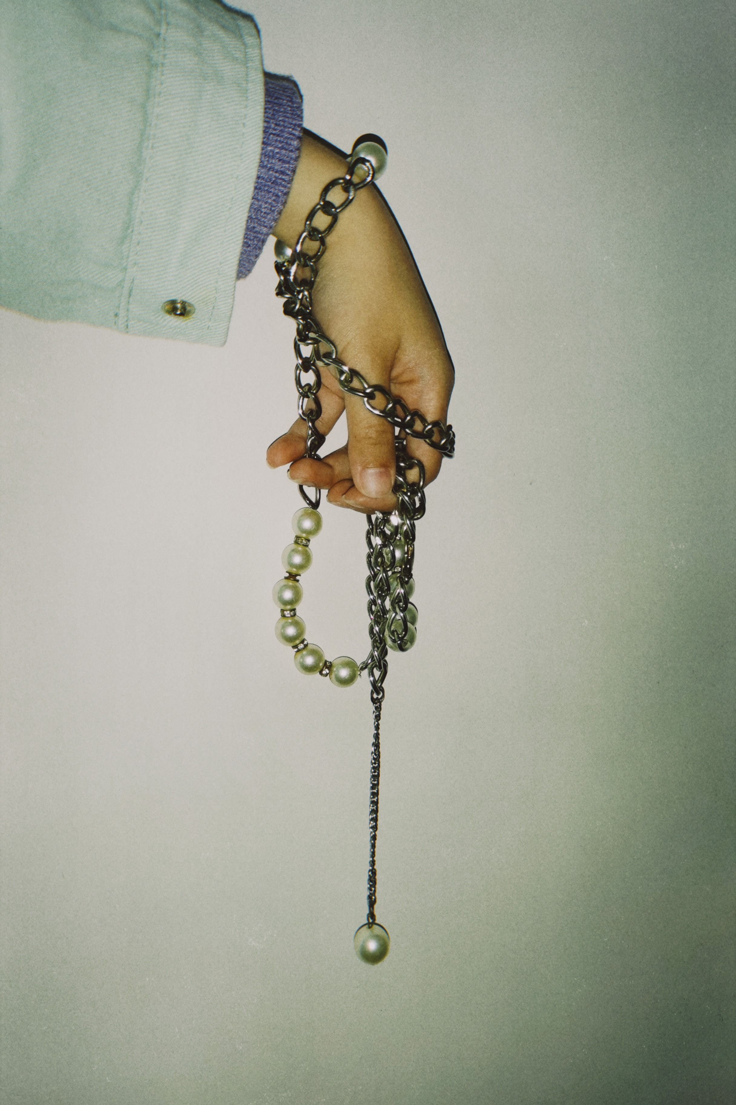 Hand Holding Chain and Pearl Necklace · Free Stock Photo