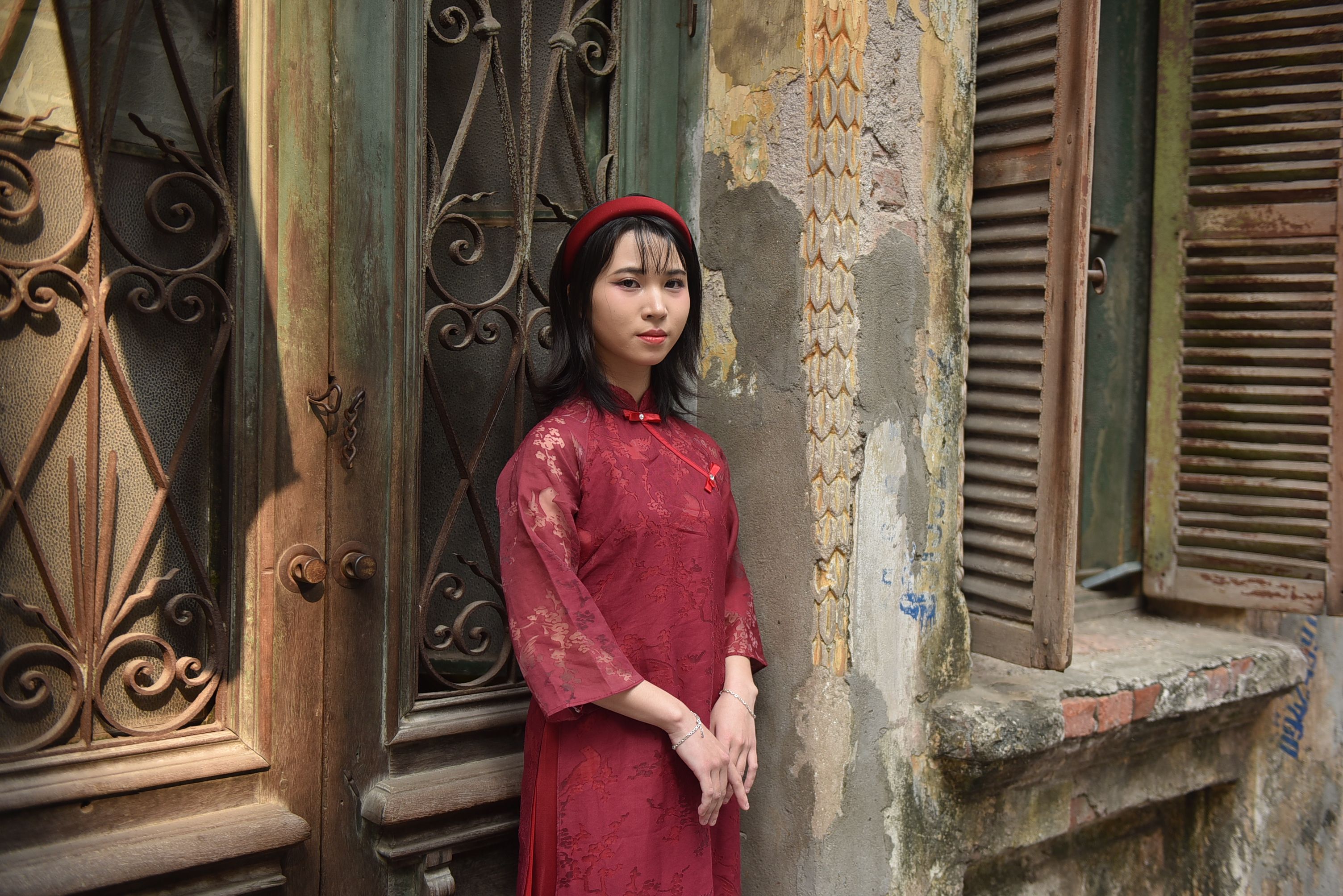 Woman in Traditional Red Dress Against Rustic Wall · Free Stock Photo