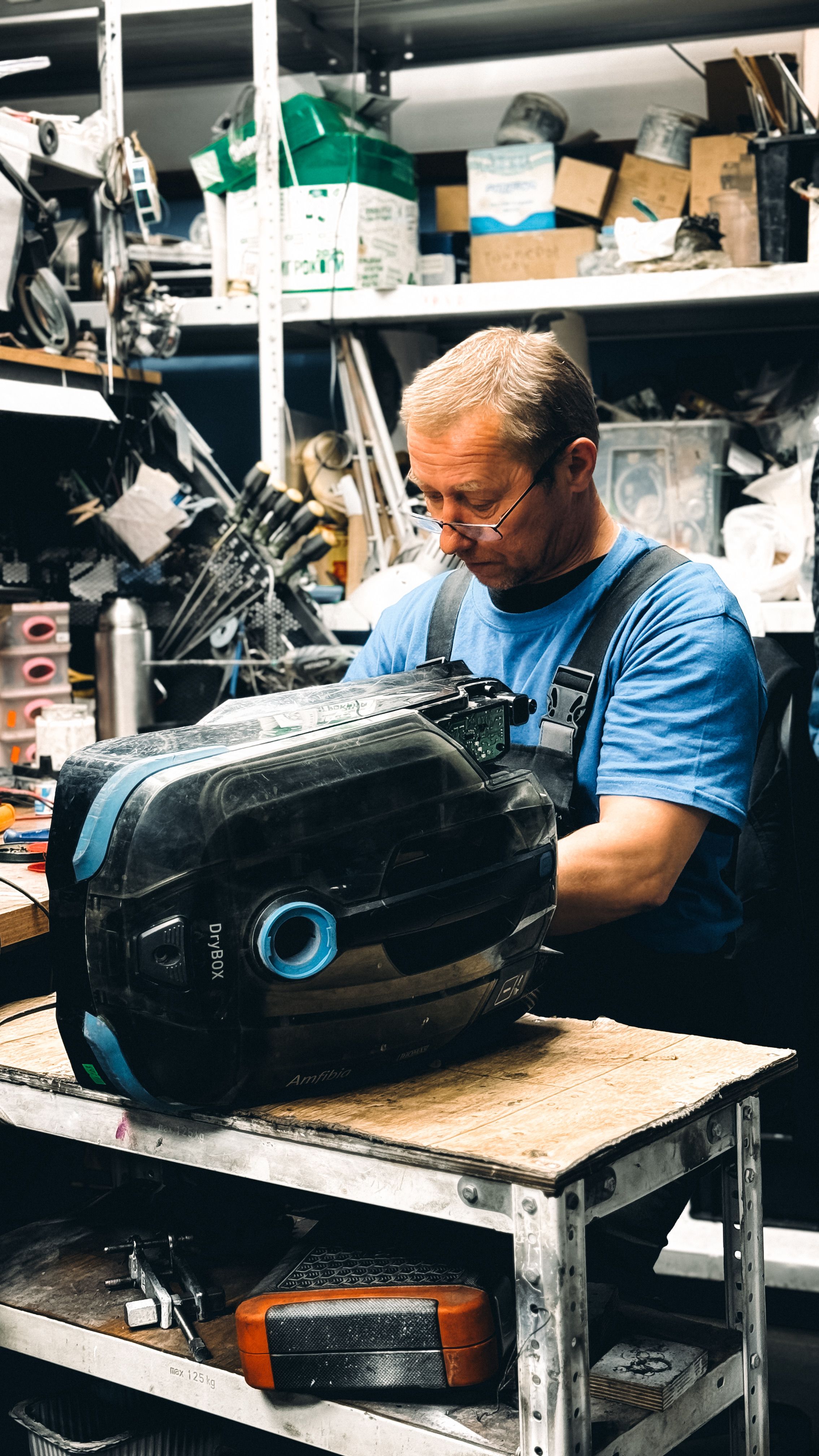 Man Repairing Vacuum Cleaner in Workshop · Free Stock Photo