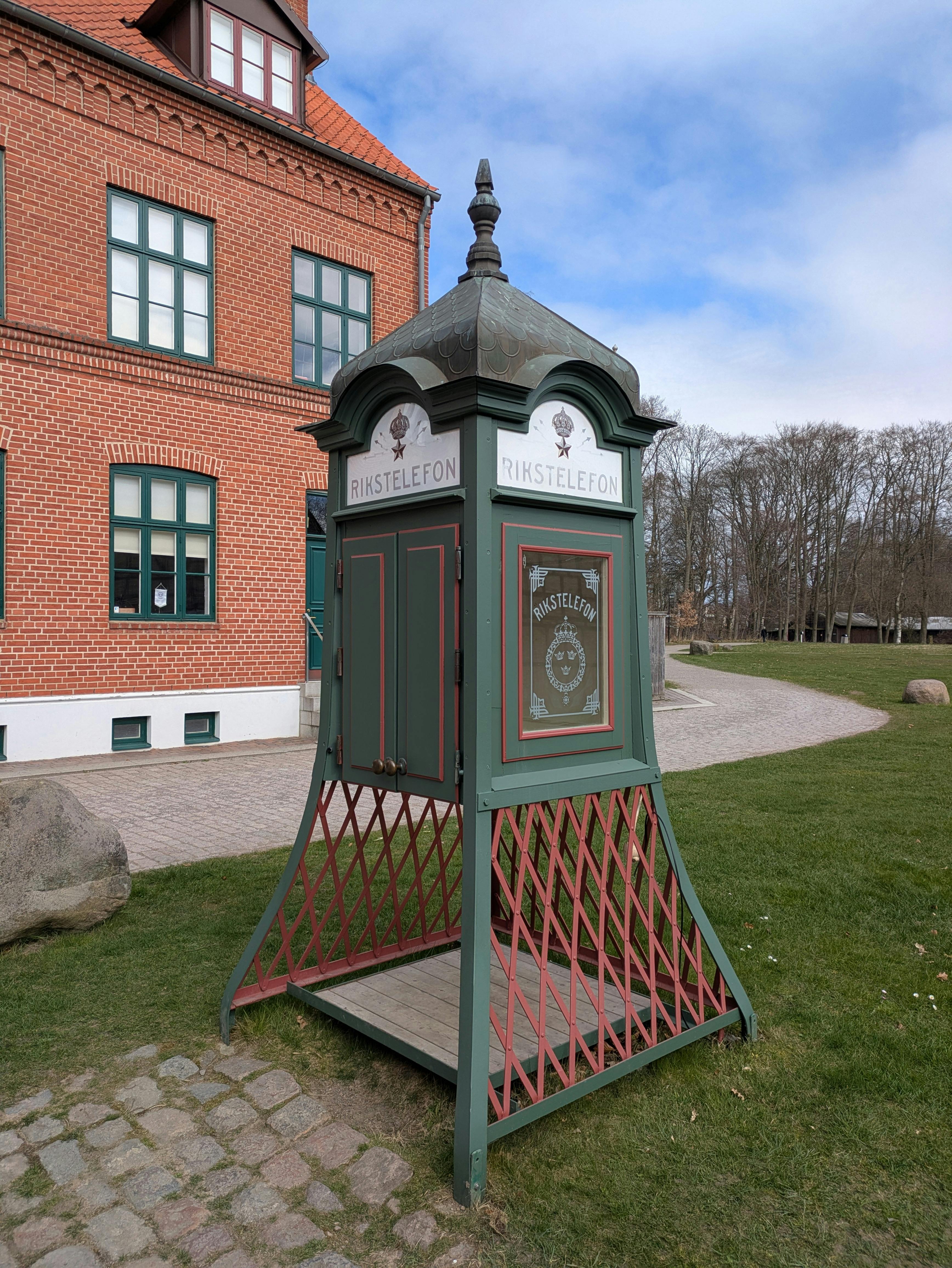 Historical Norwegian Phone Booth Near Brick Building · Free Stock Photo