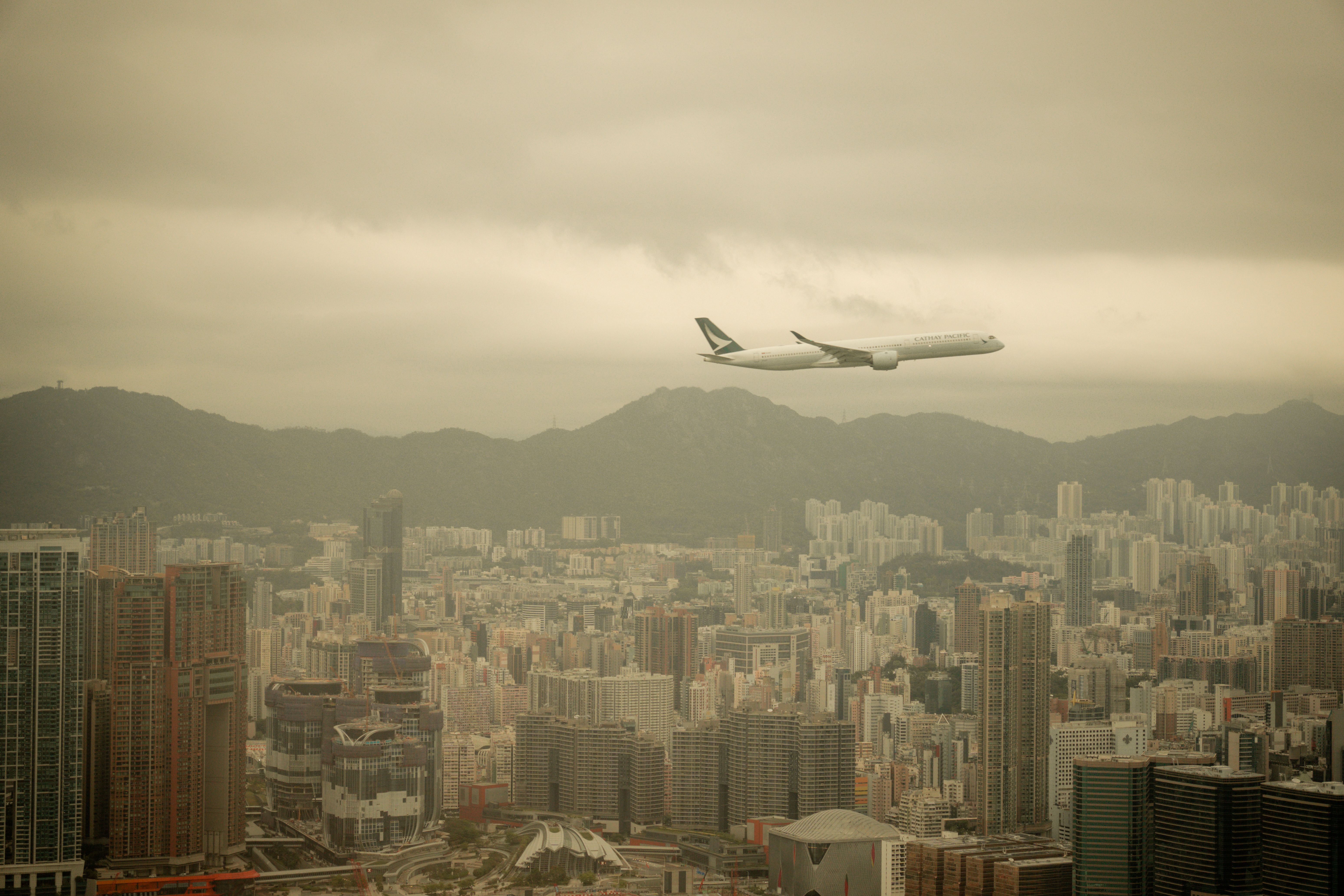 Airplane Flying Over Hong Kong Skyline · Free Stock Photo