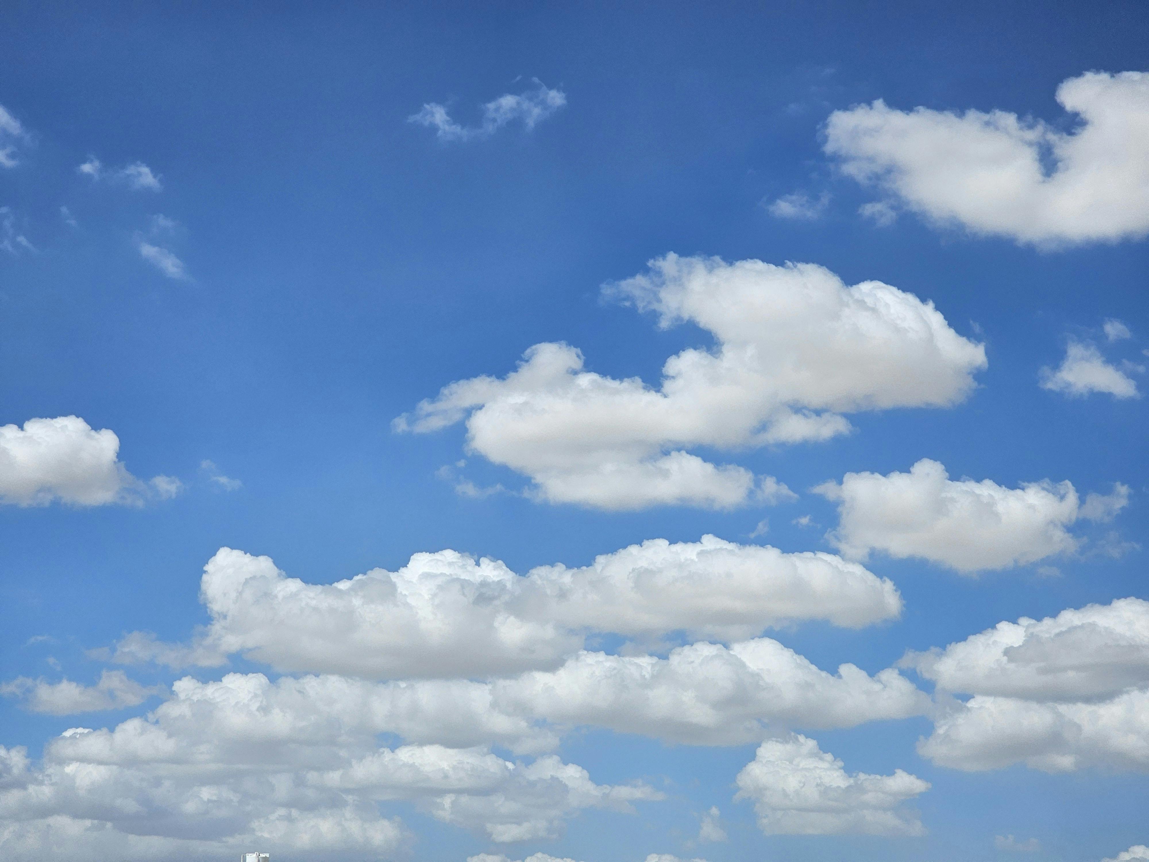 Bright Blue Sky with Fluffy White Clouds · Free Stock Photo