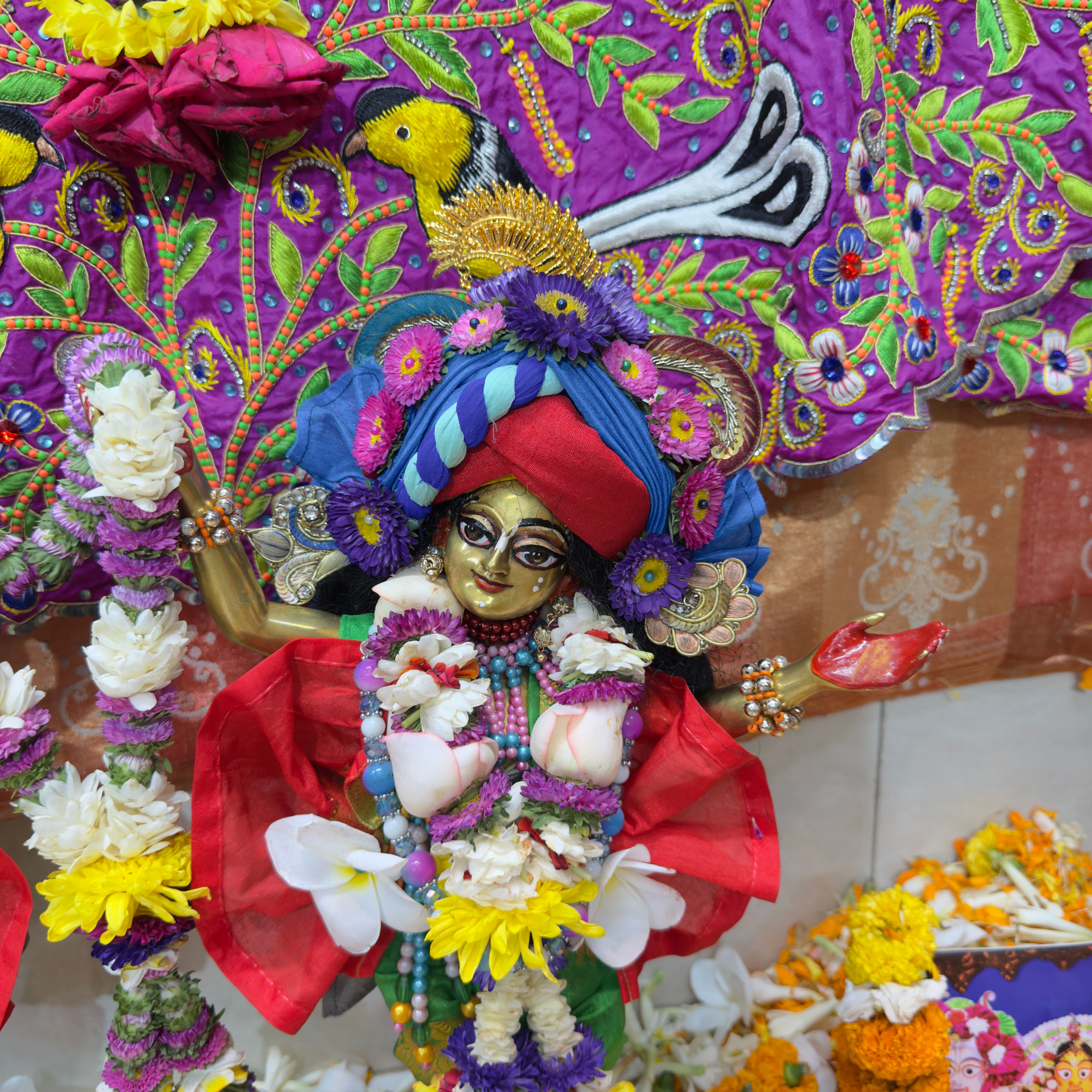 Vibrant Indian Deity Sculpture with Flowers · Free Stock Photo