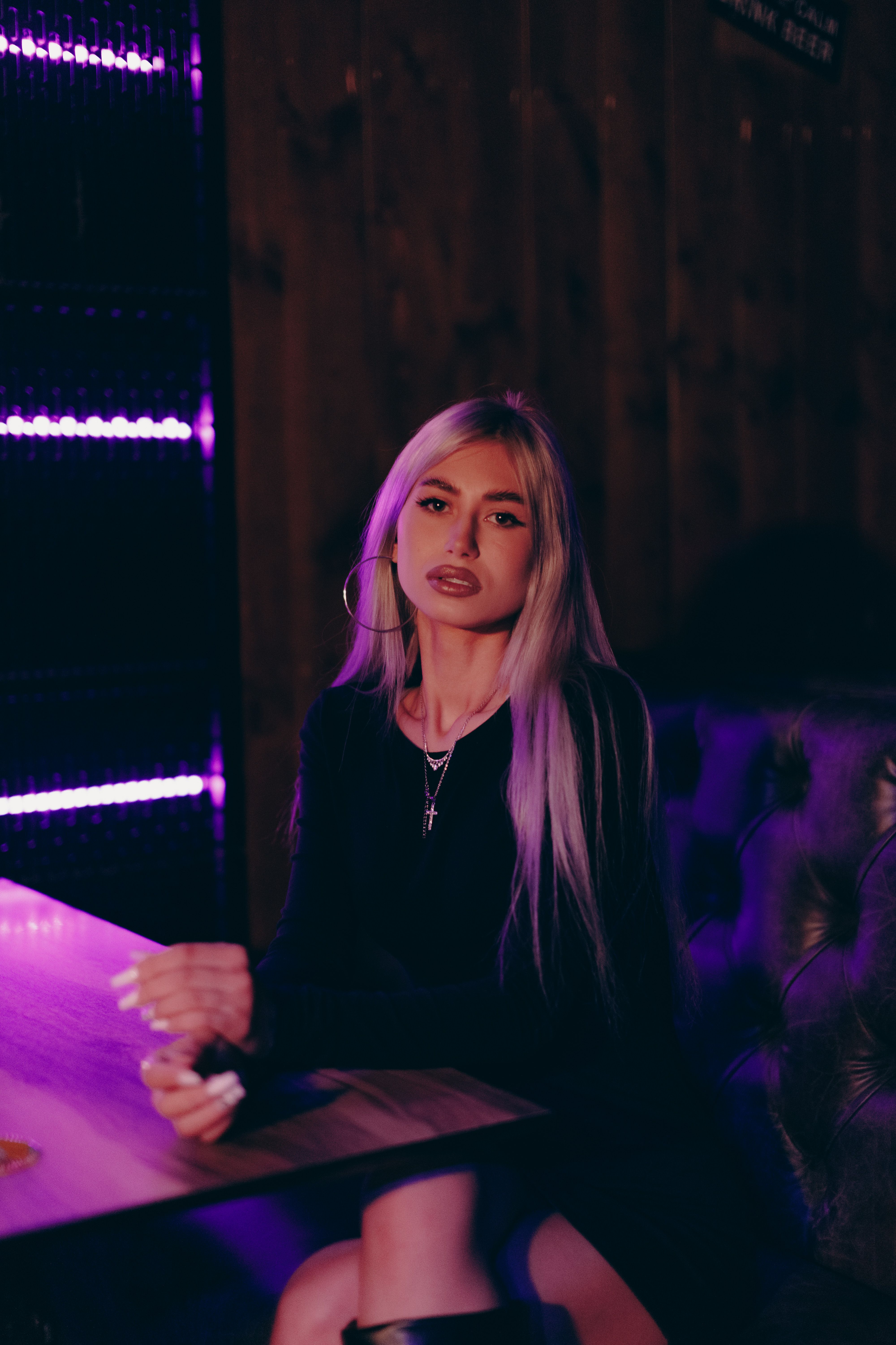 Trendy Woman in Dimly Lit Cafe with Neon Lights · Free Stock Photo