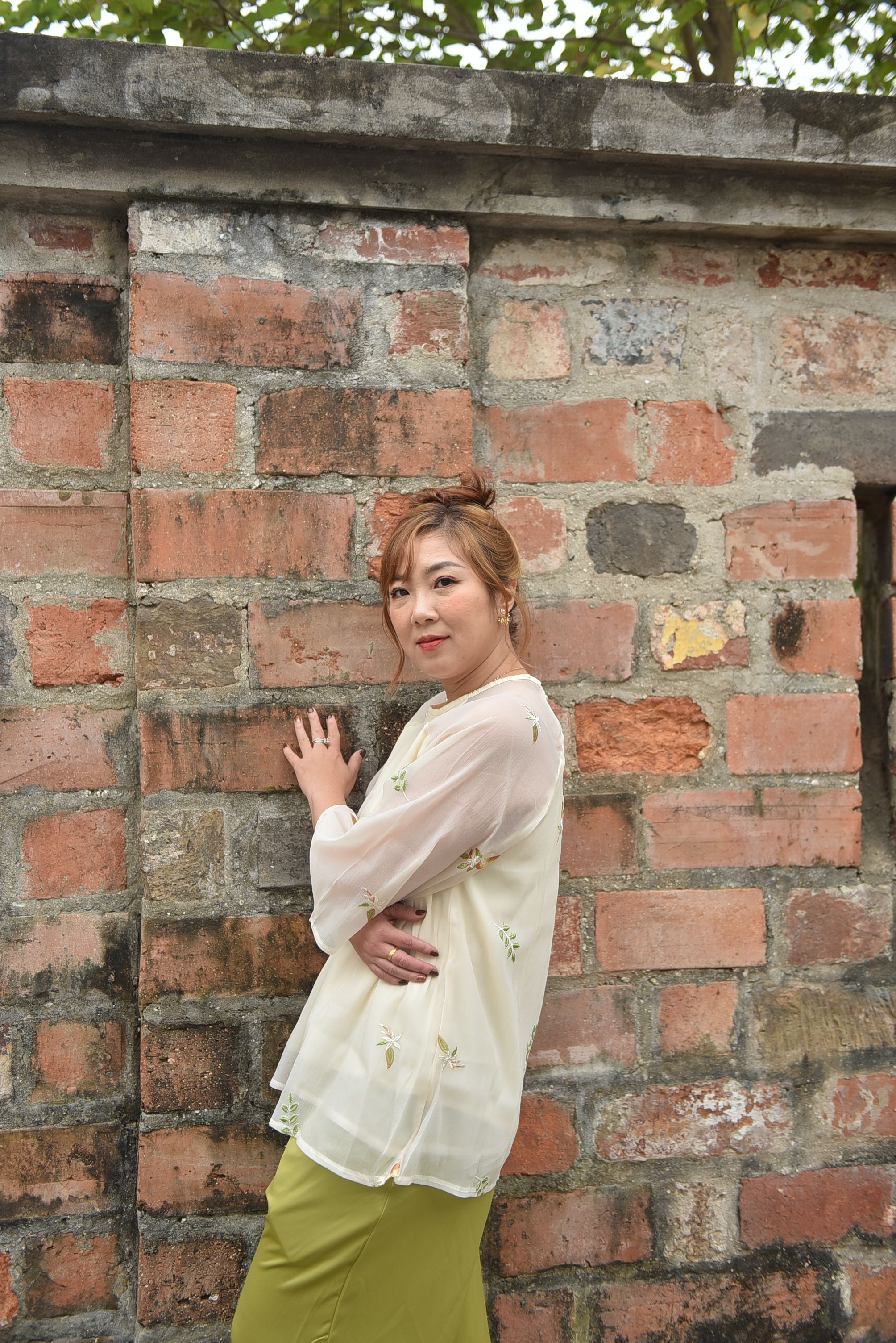 Portrait of a Young Woman Against Brick Wall · Free Stock Photo