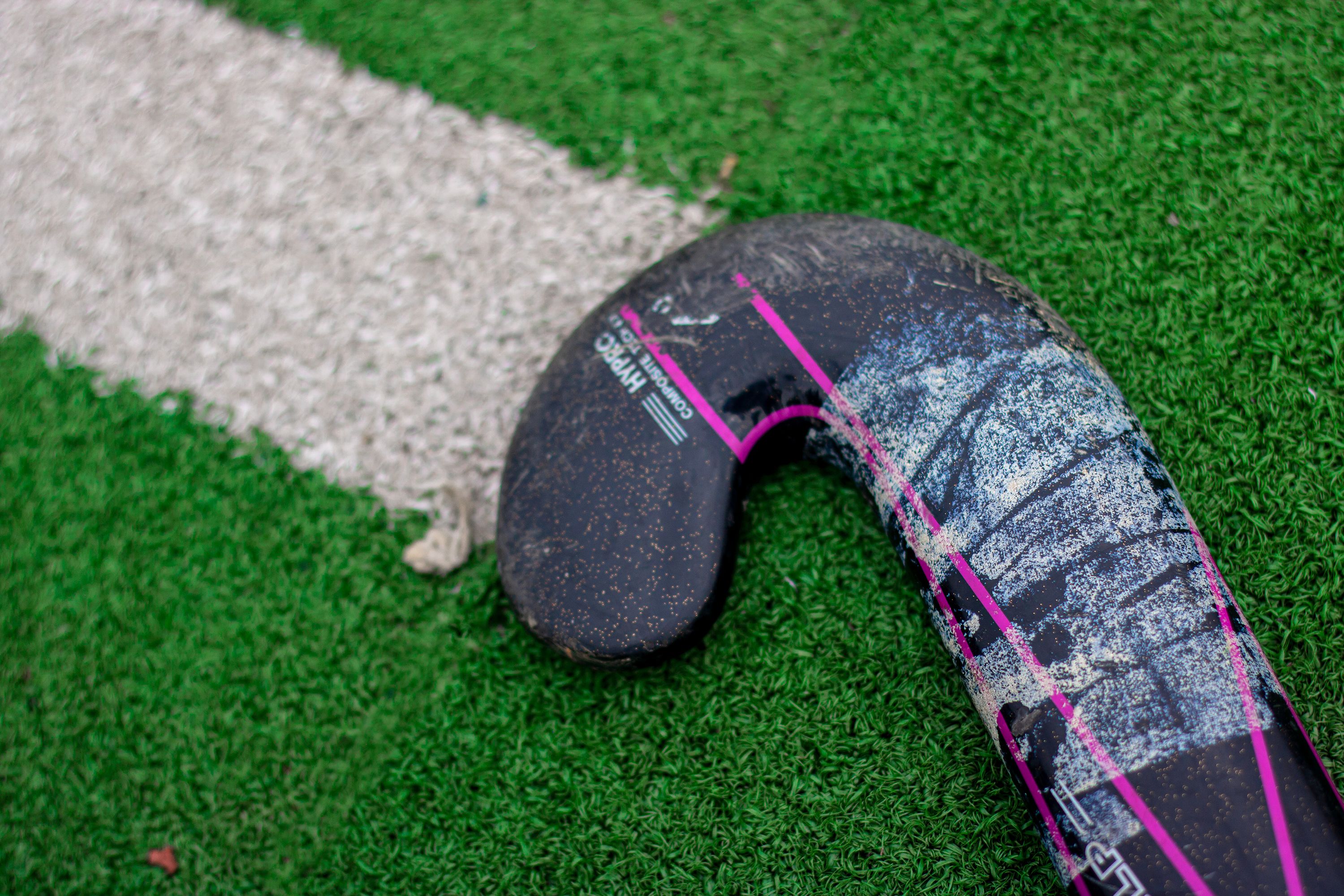 Close-up of Hockey Stick on Grass Turf Field · Free Stock Photo