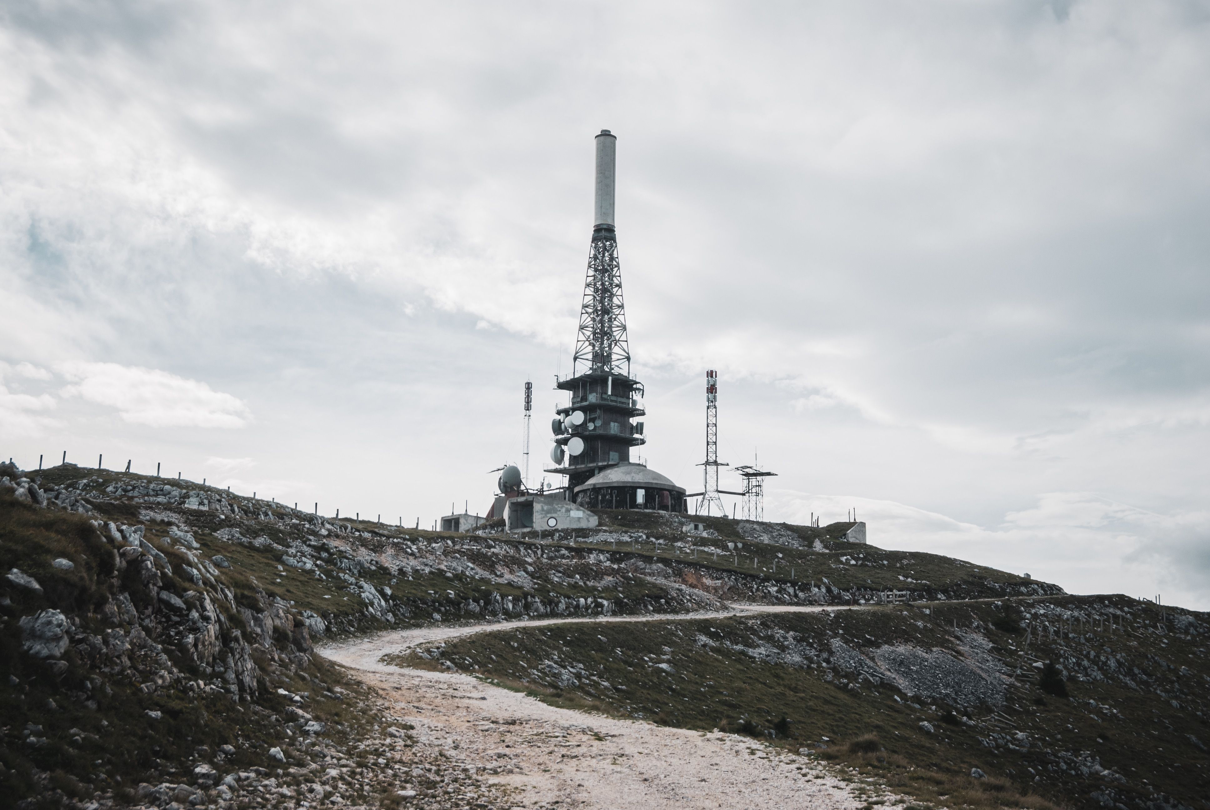 Remote Mountain Communications Tower Against Cloudy Sky · Free Stock Photo