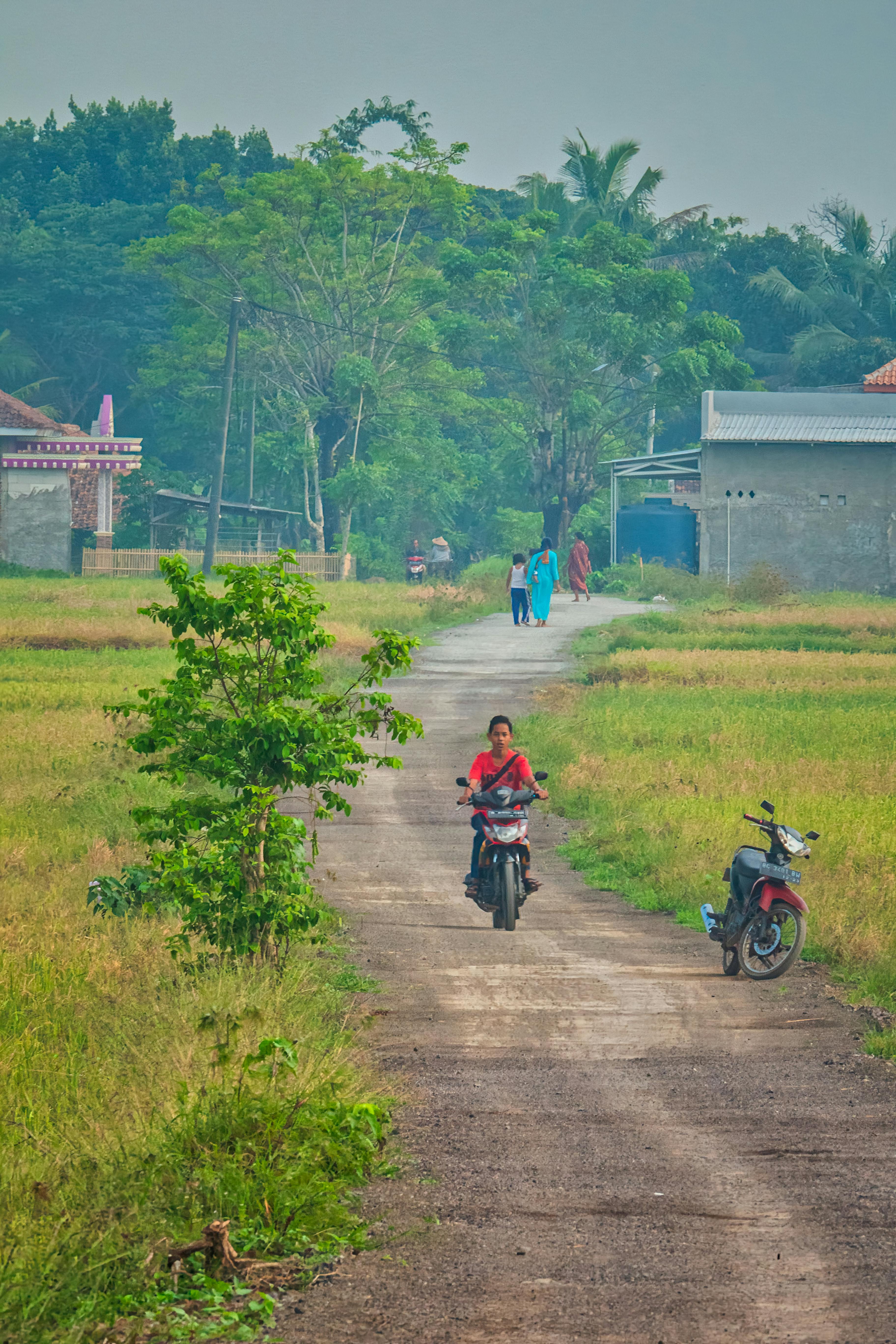 Rural Pathway with Motorcyclist in Jakarta, Indonesia · Free Stock Photo