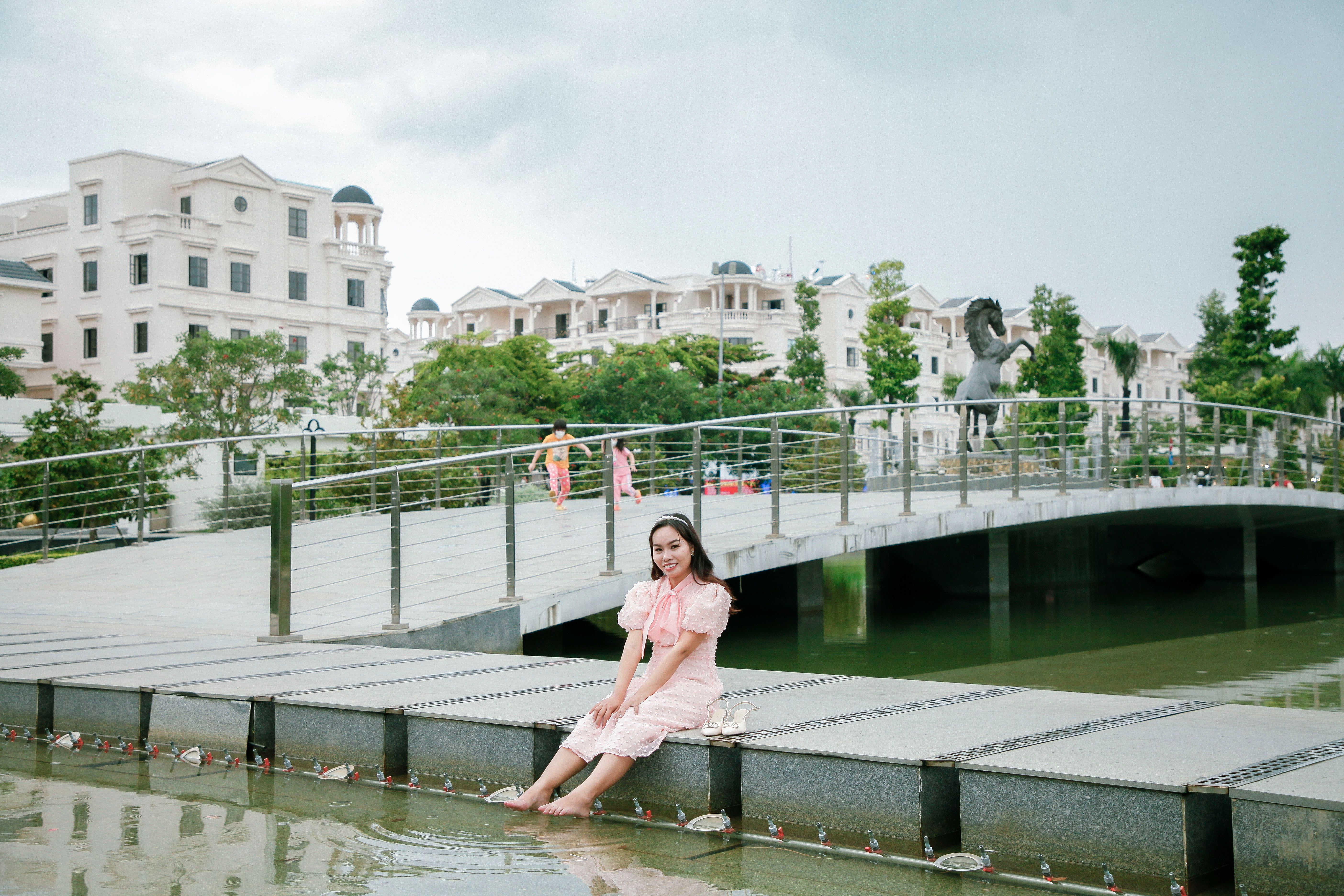 Woman Enjoying Riverside View near Elegant Bridge · Free Stock Photo
