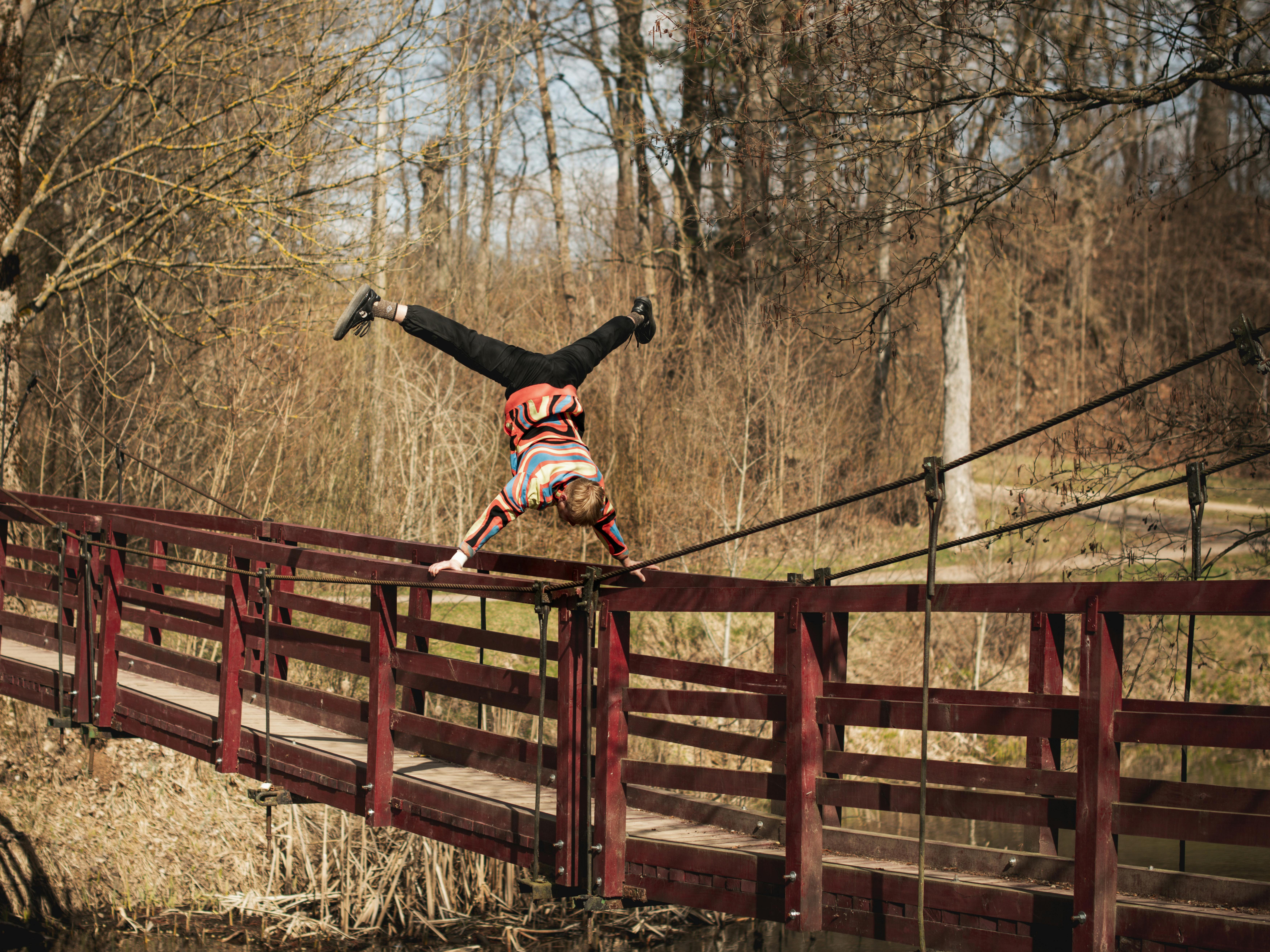 Acrobatic Pose on Rustic Bridge in Vilnius · Free Stock Photo