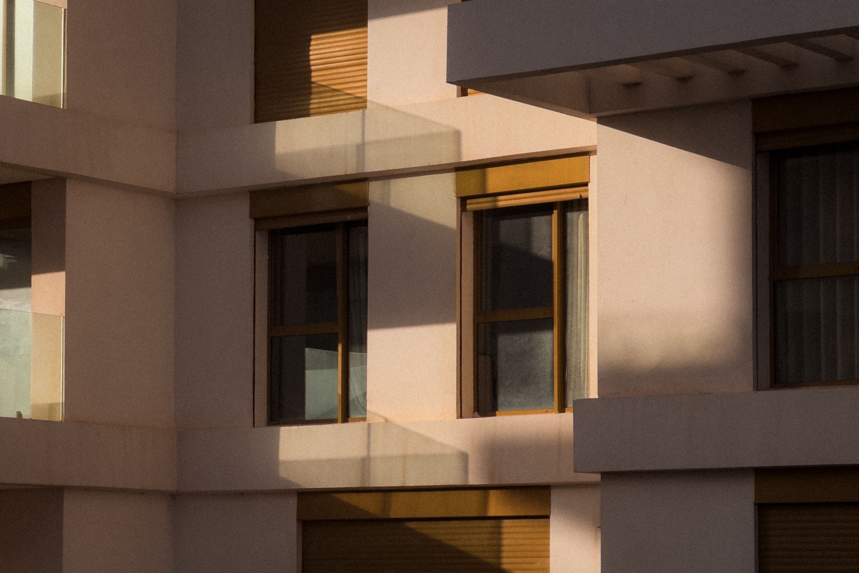 Modern Building Façade with Sunlit Shadows · Free Stock Photo