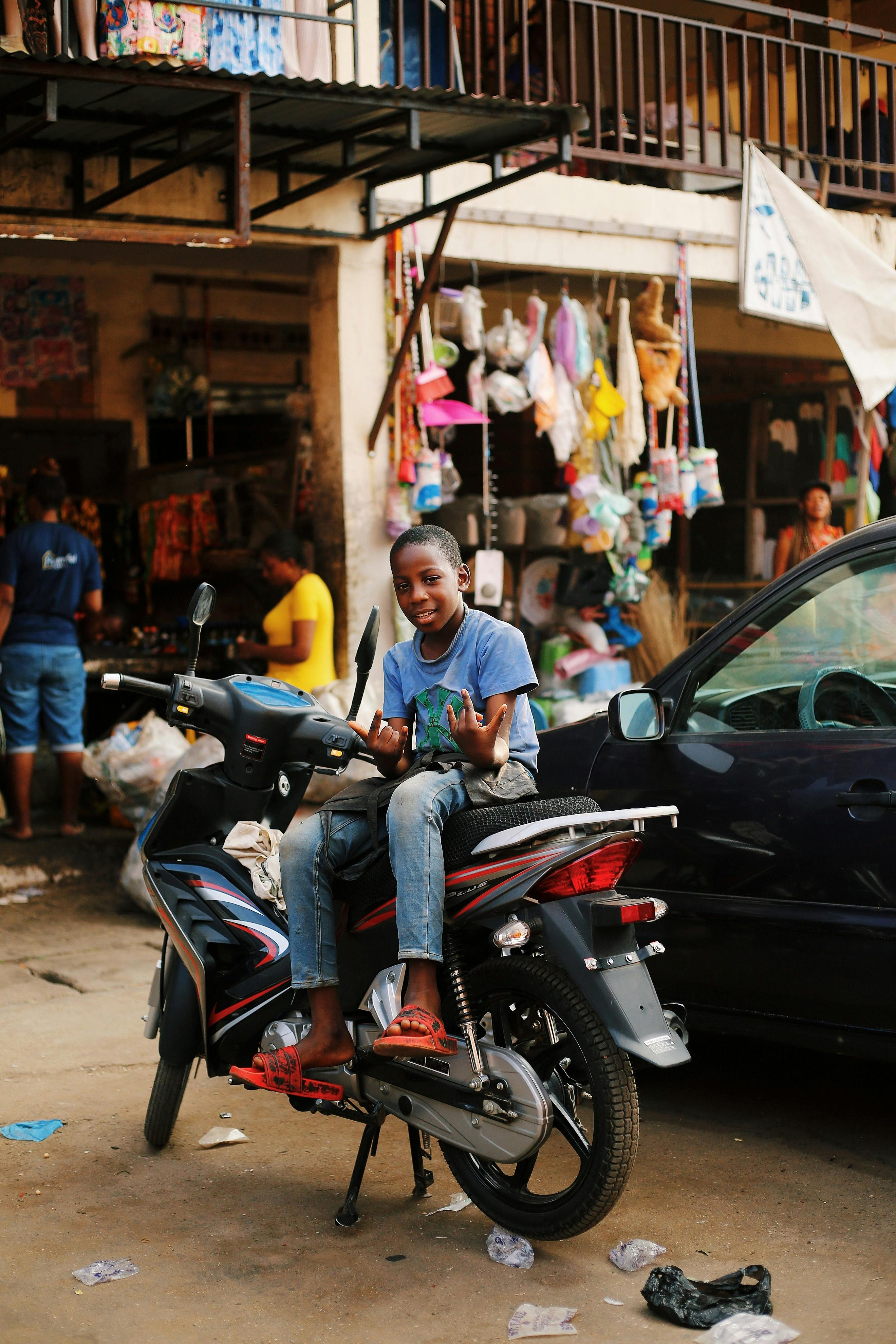Boy on Motorcycle in Bustling Abuja Market · Free Stock Photo