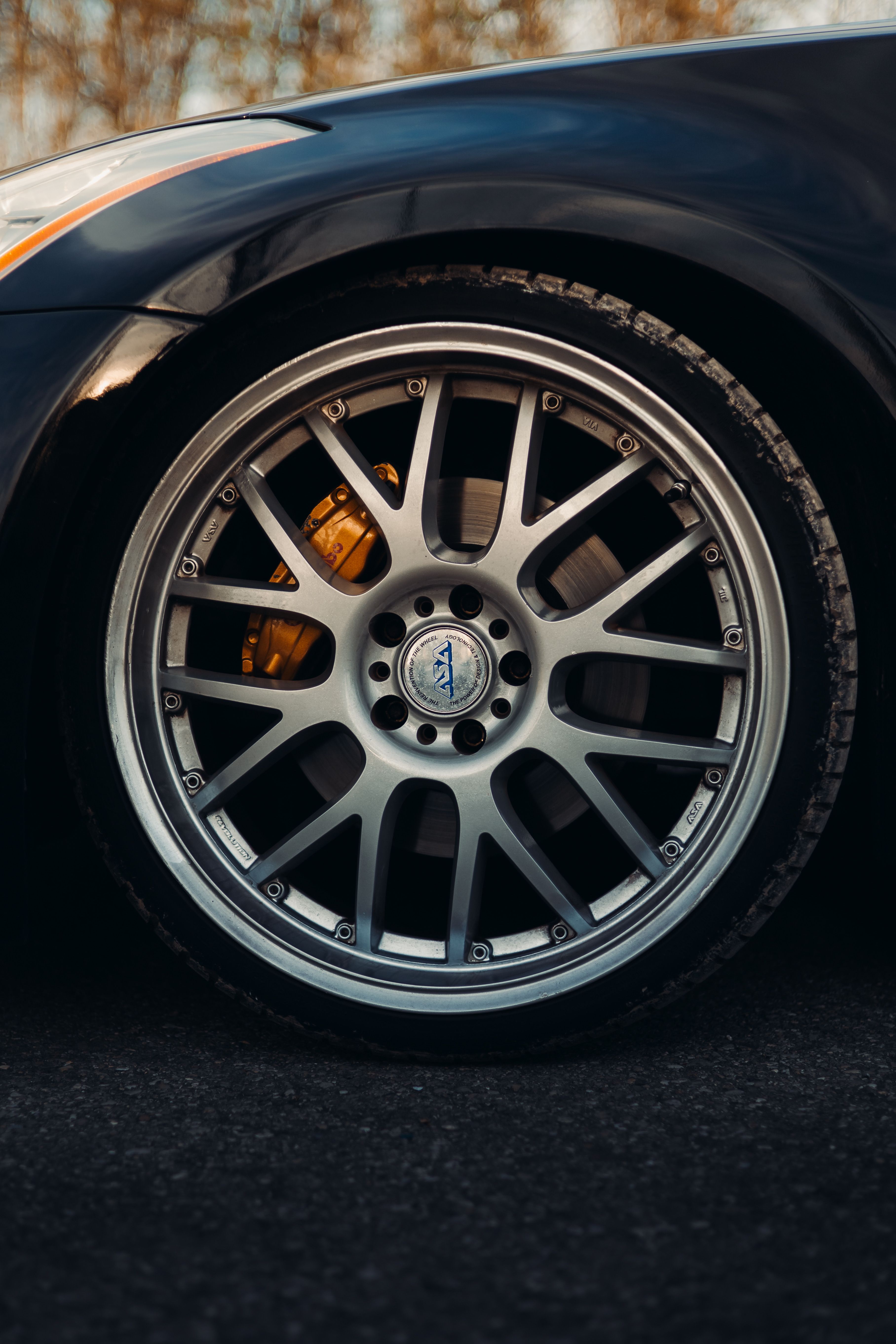 Close-up of Stylish Car Alloy Wheel on Asphalt · Free Stock Photo